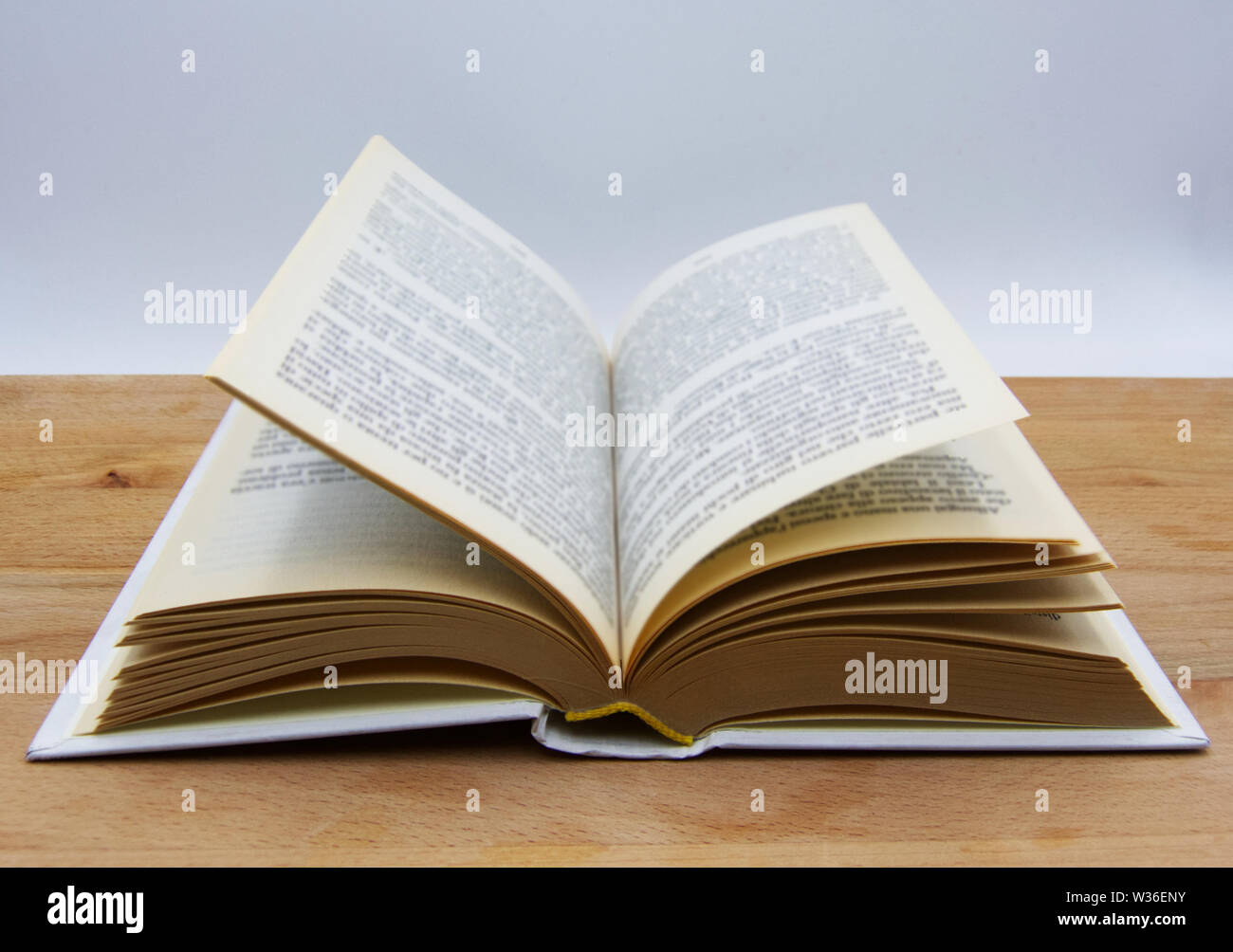 Open book on wooden table, white background Stock Photo - Alamy