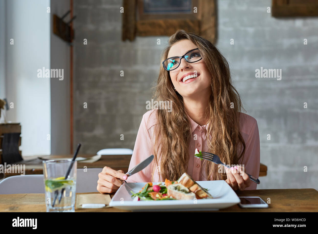 Happy woman eating lunch in restaurant Stock Photo - Alamy