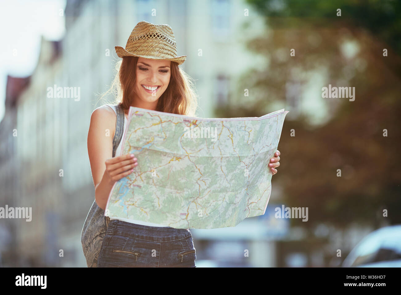 Attractive young woman reading map in the city Stock Photo - Alamy