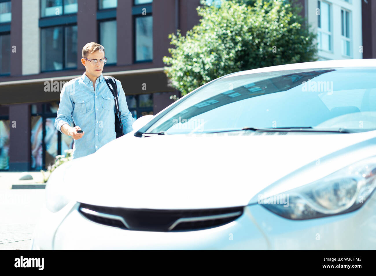 Dark-haired businessman opening his car while heading to work Stock ...