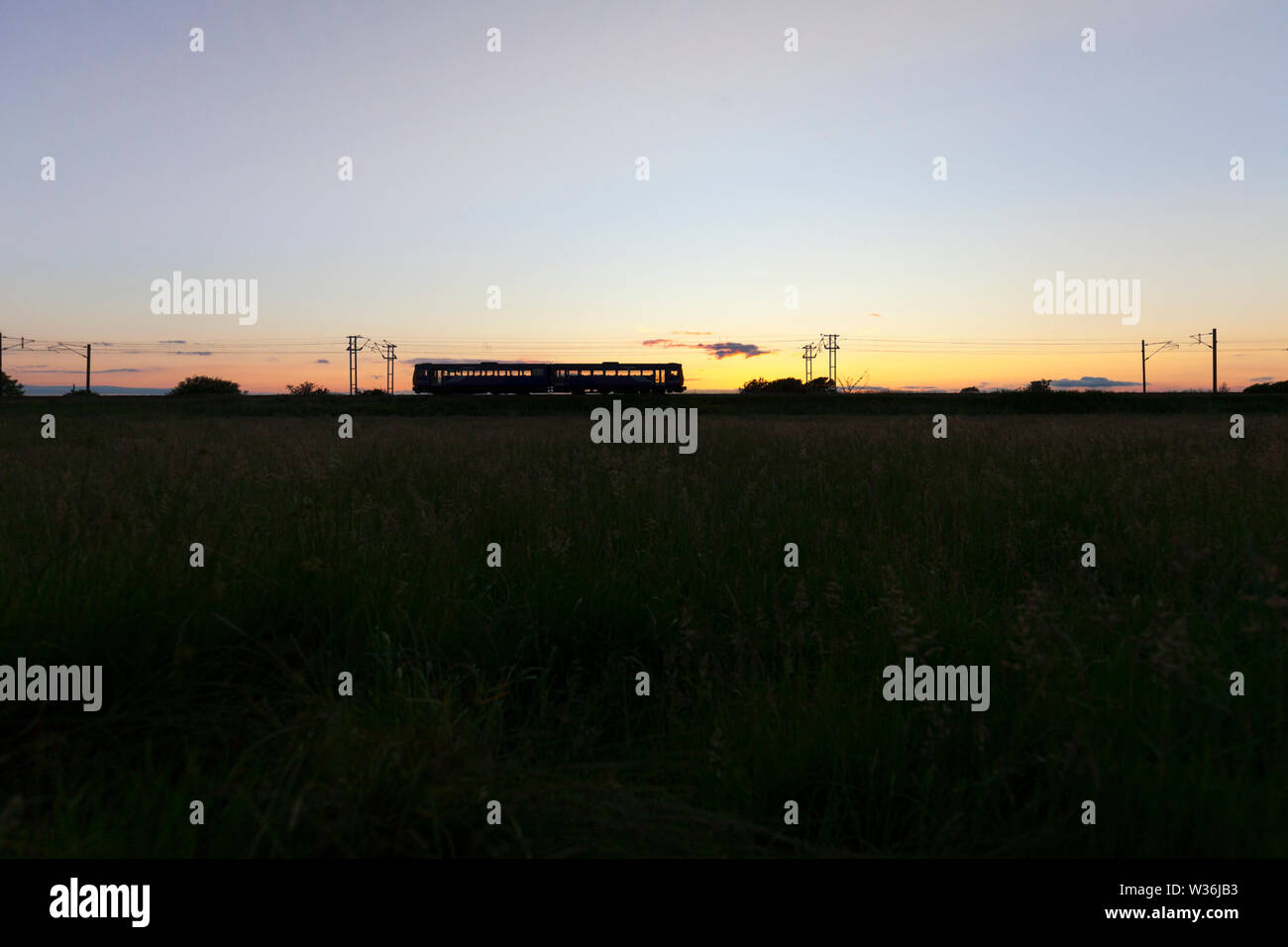 A Arriva Northern Rail class 142 pacer train at sunset passing Bolton ...