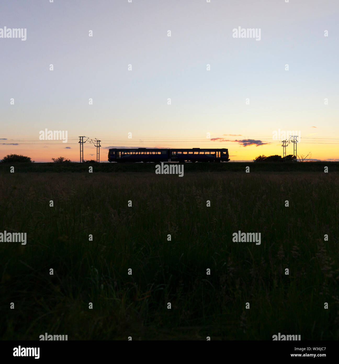 A Arriva Northern Rail class 142 pacer train at sunset passing Bolton ...