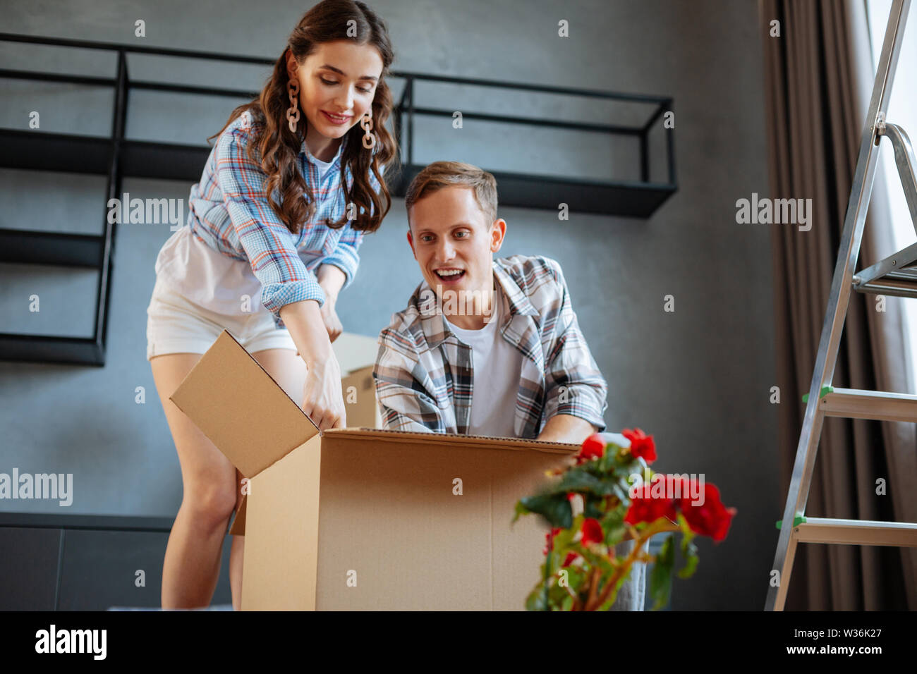Just married couple unpacking box while moving to new house Stock Photo ...