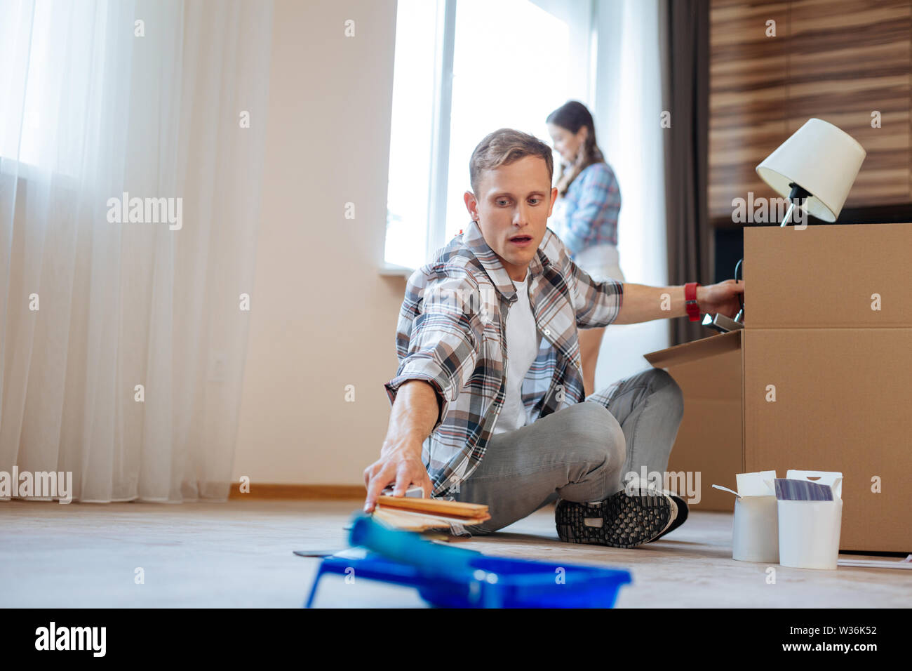 Husband unpacking the box while moving to new house Stock Photo - Alamy