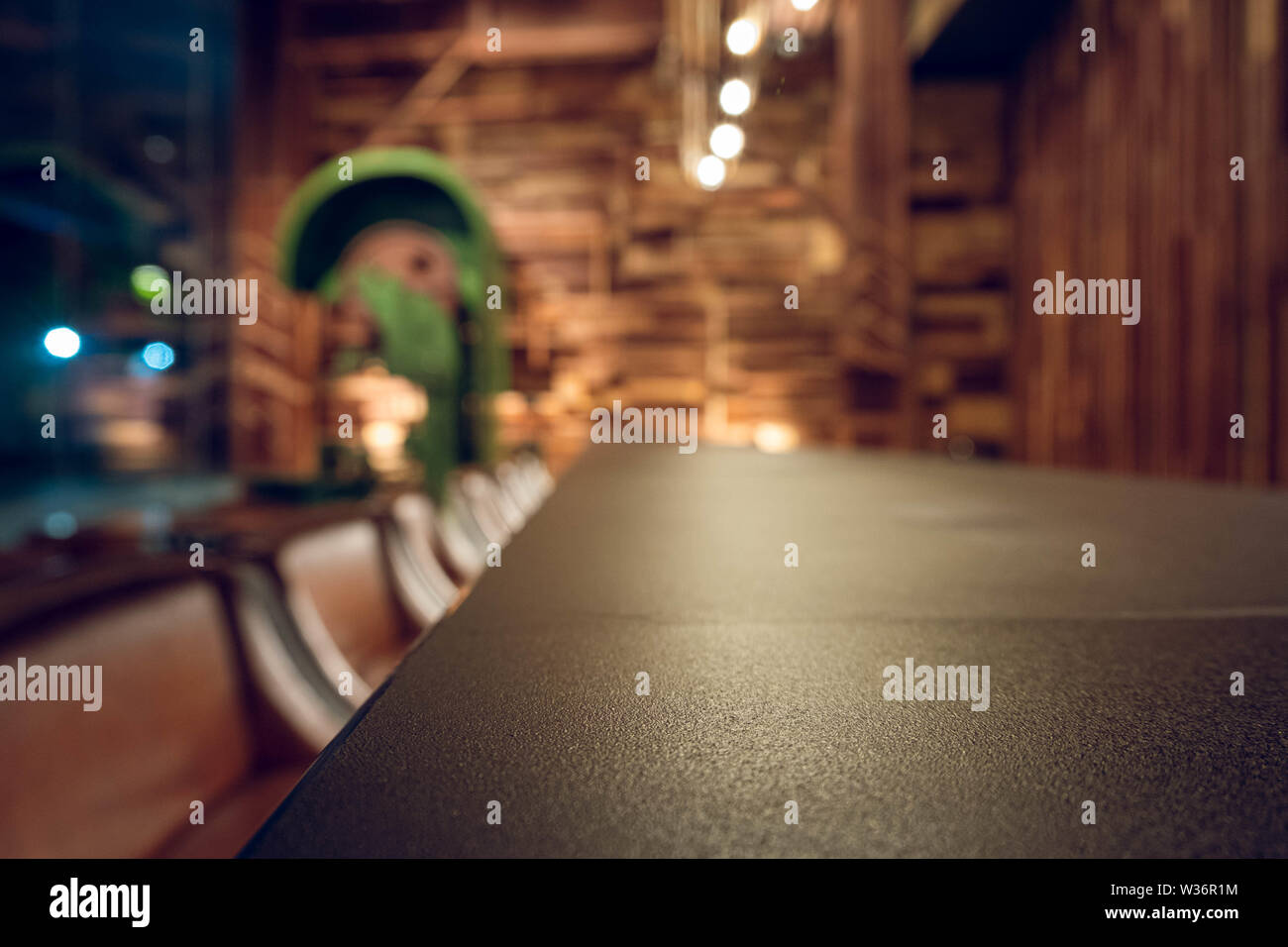 Empty wooden bar counter with defocused background and bottles of ...