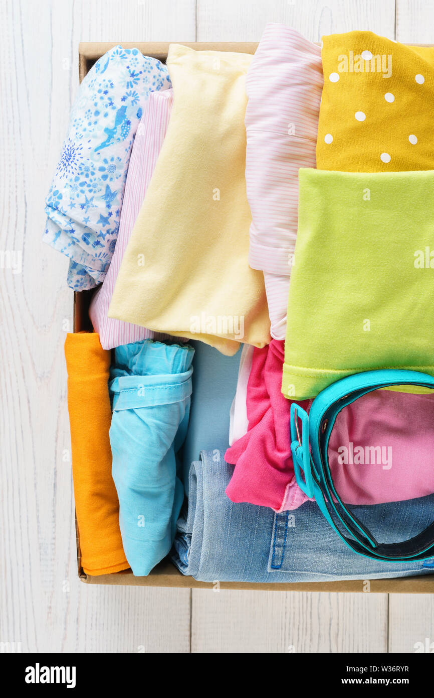 Various colorful clothes in a box for shipping or donation. Clothing ...