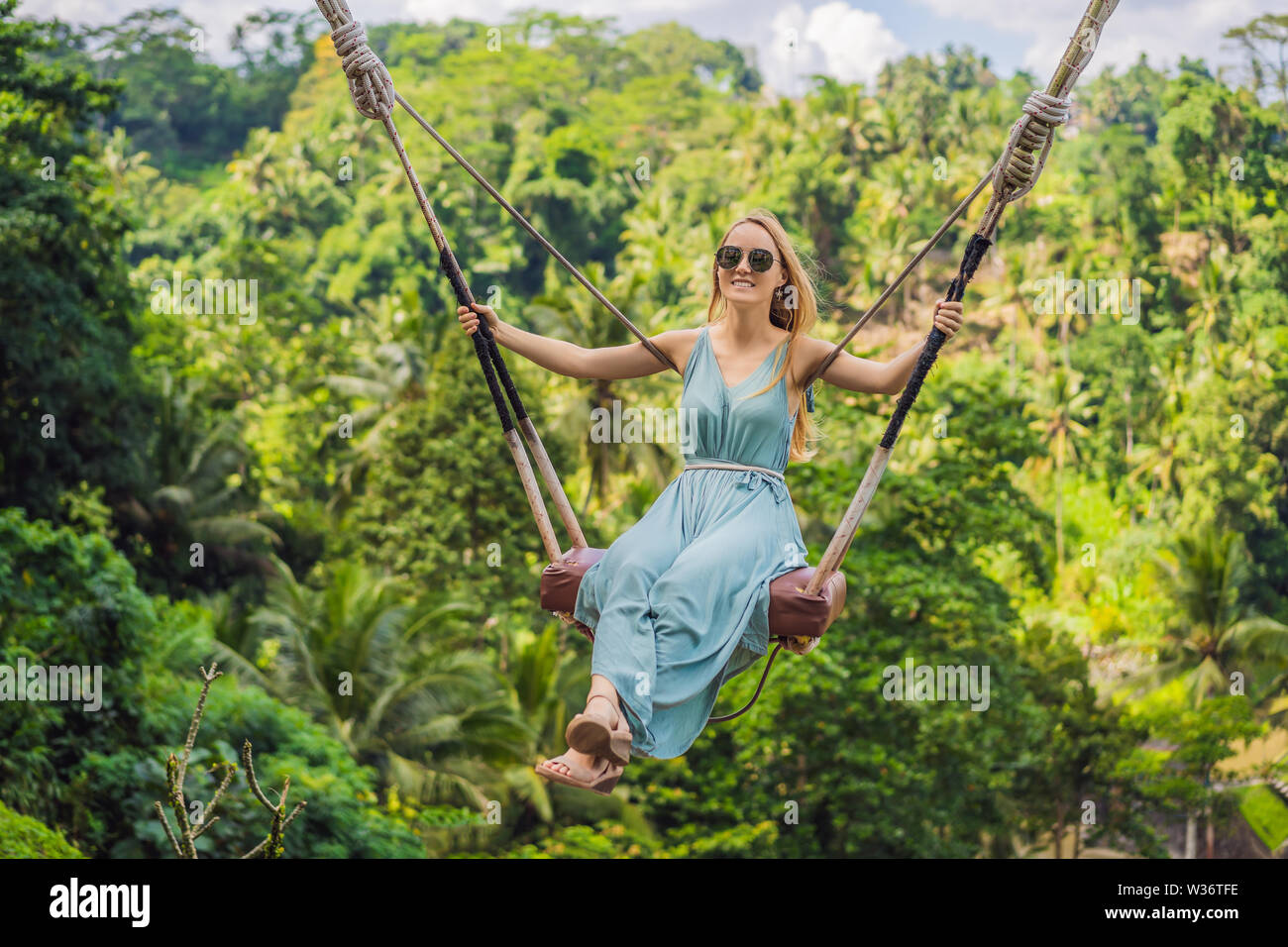 Young woman swinging in the jungle rainforest of Bali island, Indonesia ...