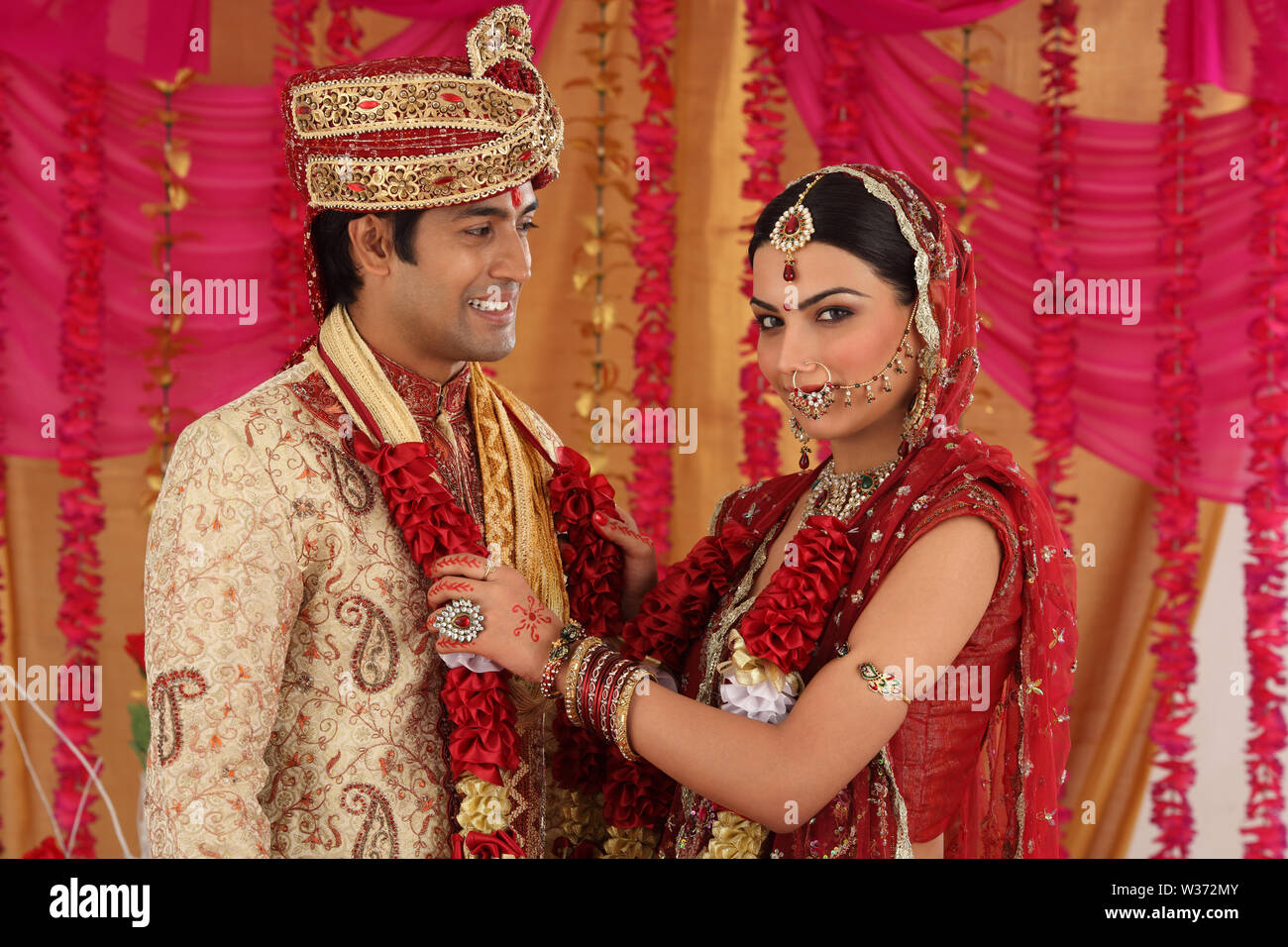 Couple performing Mala Badal ceremony in wedding mandap Stock Photo - Alamy