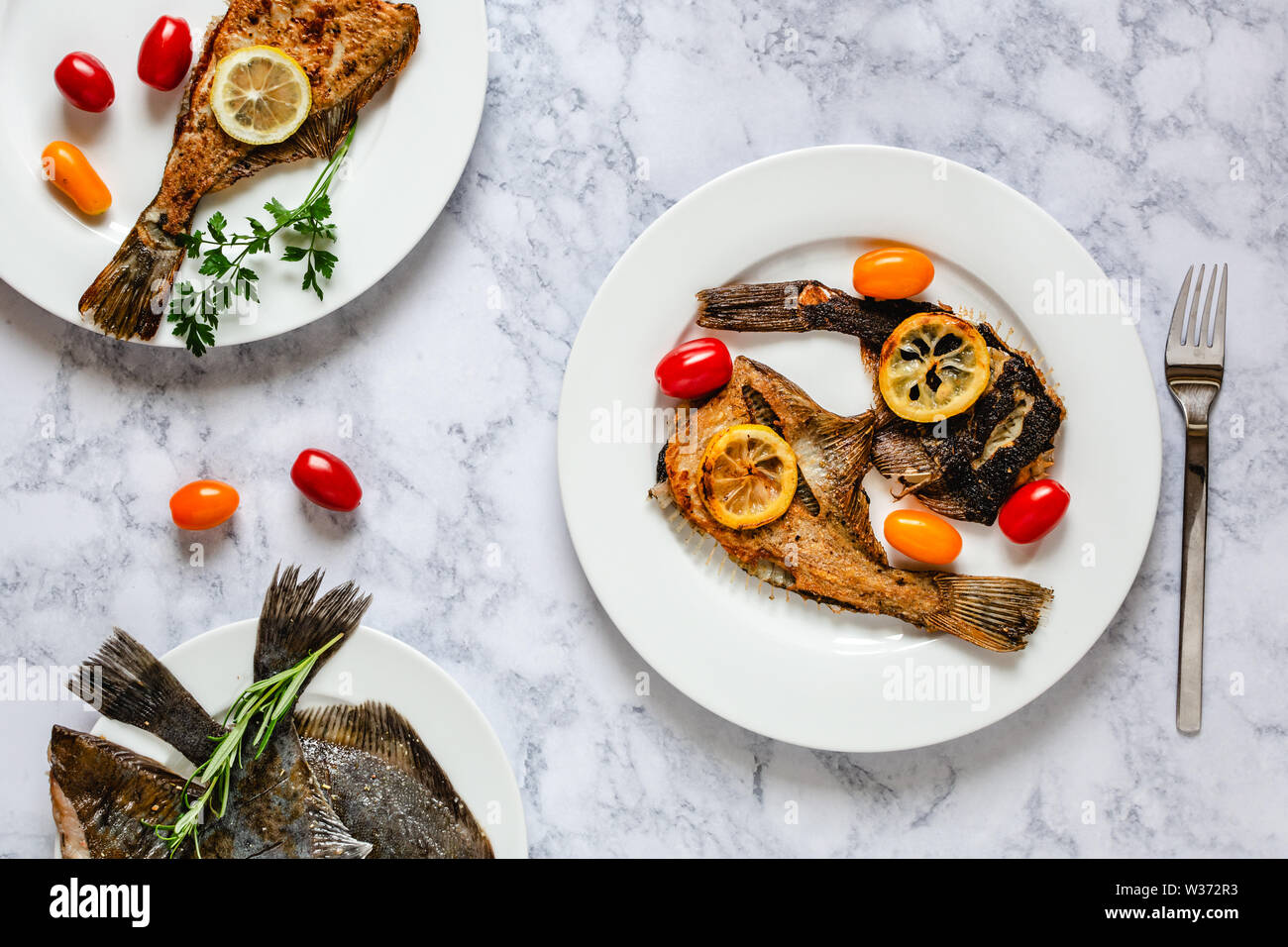 Grilled flounder fish served on white plate Stock Photo - Alamy