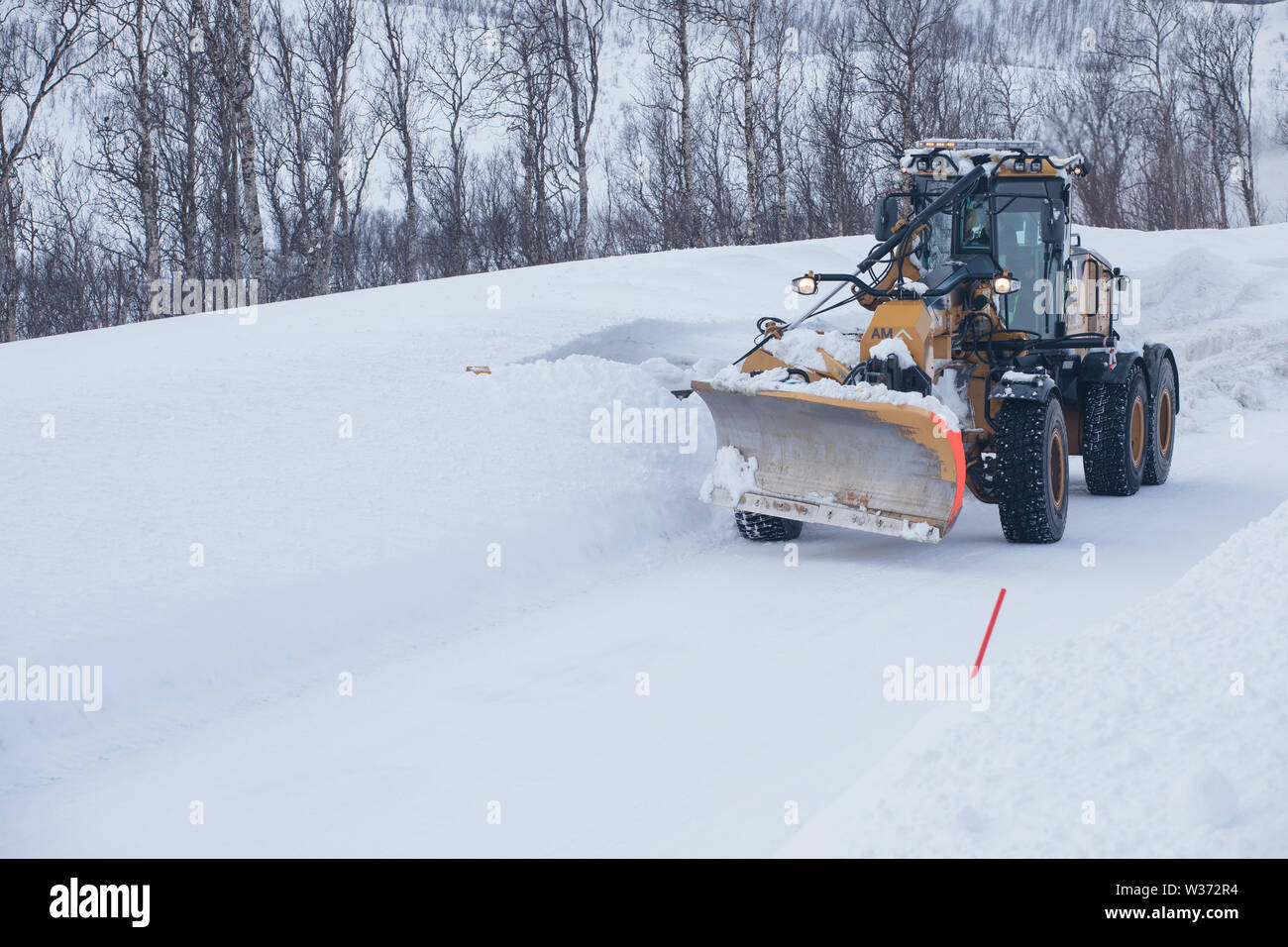 Snow plow truck clearing icy road after winter snowstorm blizzard for ...
