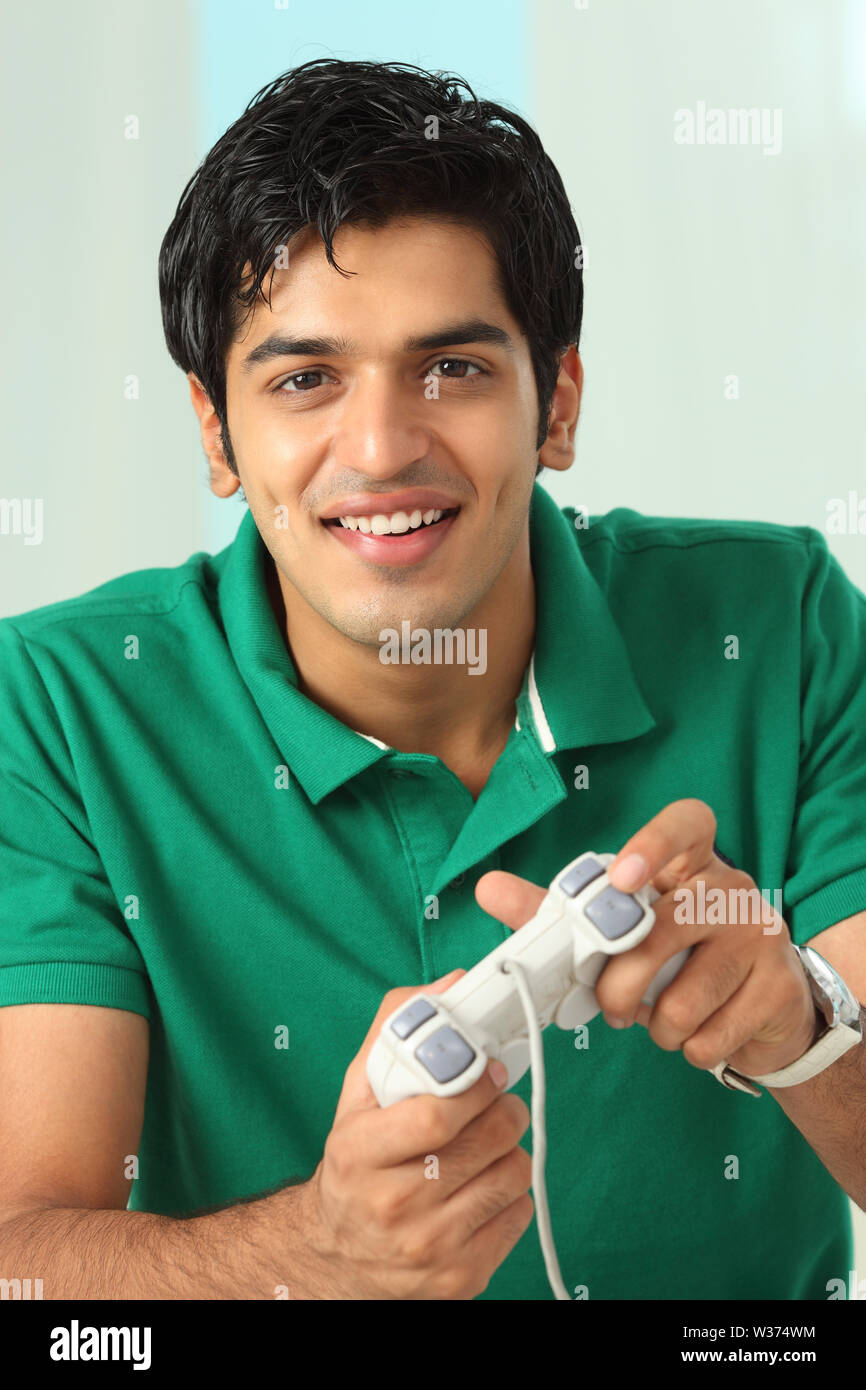 Indian young man playing video game Stock Photo - Alamy