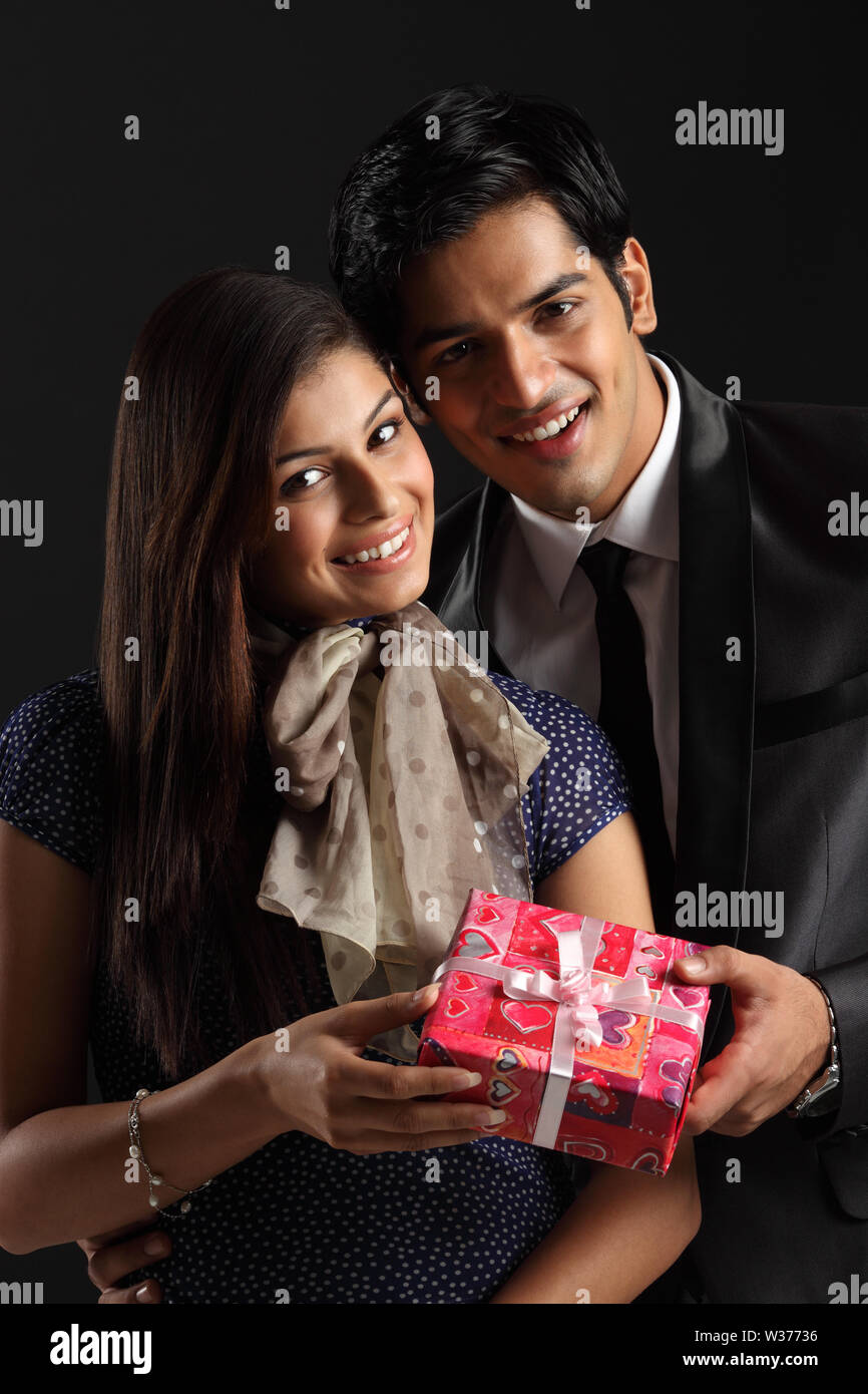 Man giving gift box to a woman Stock Photo - Alamy