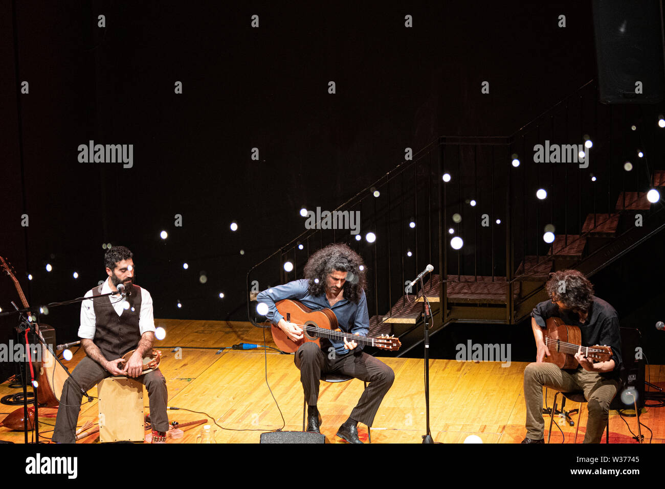 a trio of musicians from different cultures playing a live concert ...