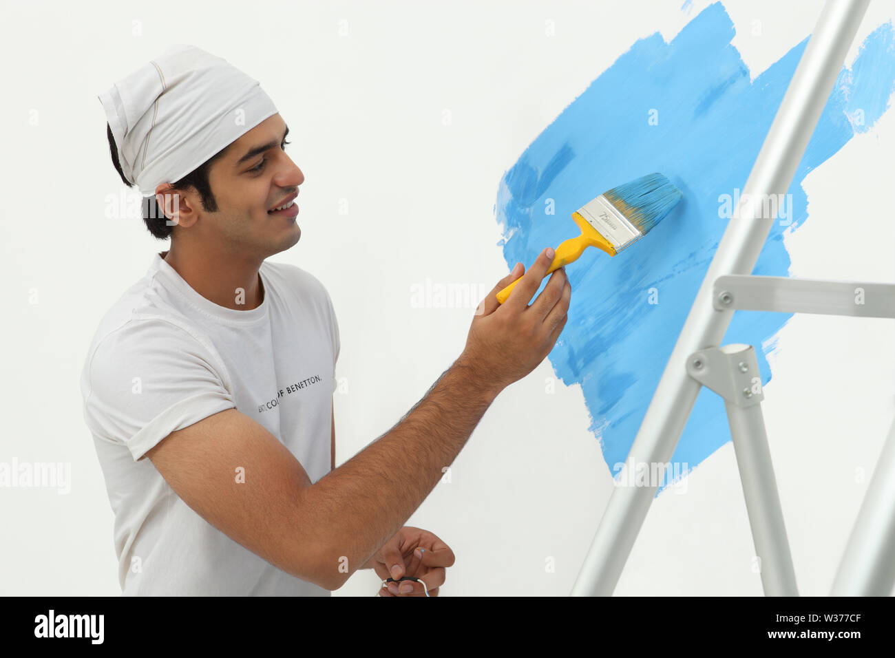 Man painting a wall and smiling Stock Photo - Alamy