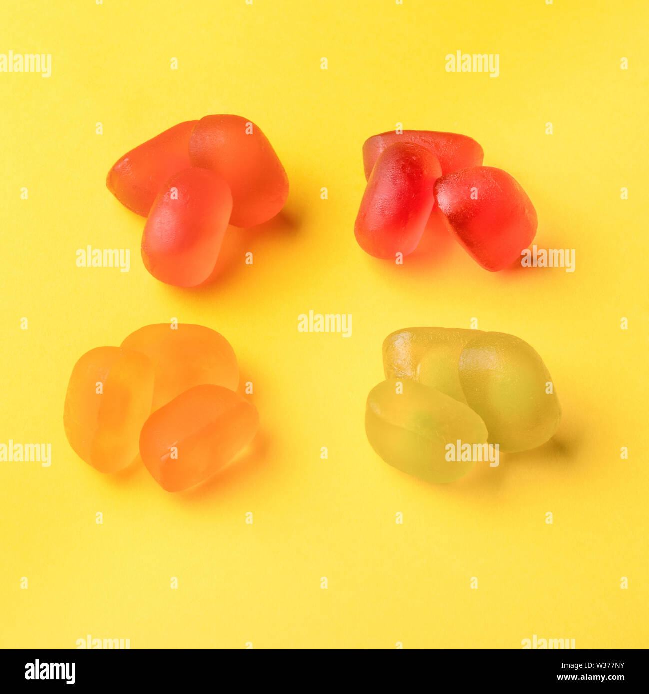 Set of four colorful chewy candy on yellow background Stock Photo - Alamy