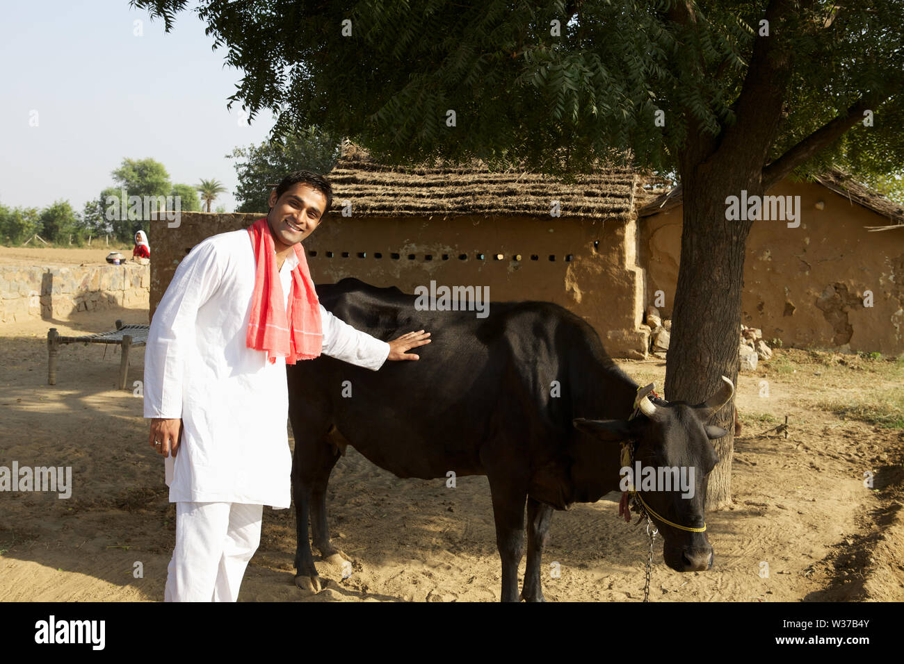 Portrait of a farmer standing with cow Stock Photo - Alamy