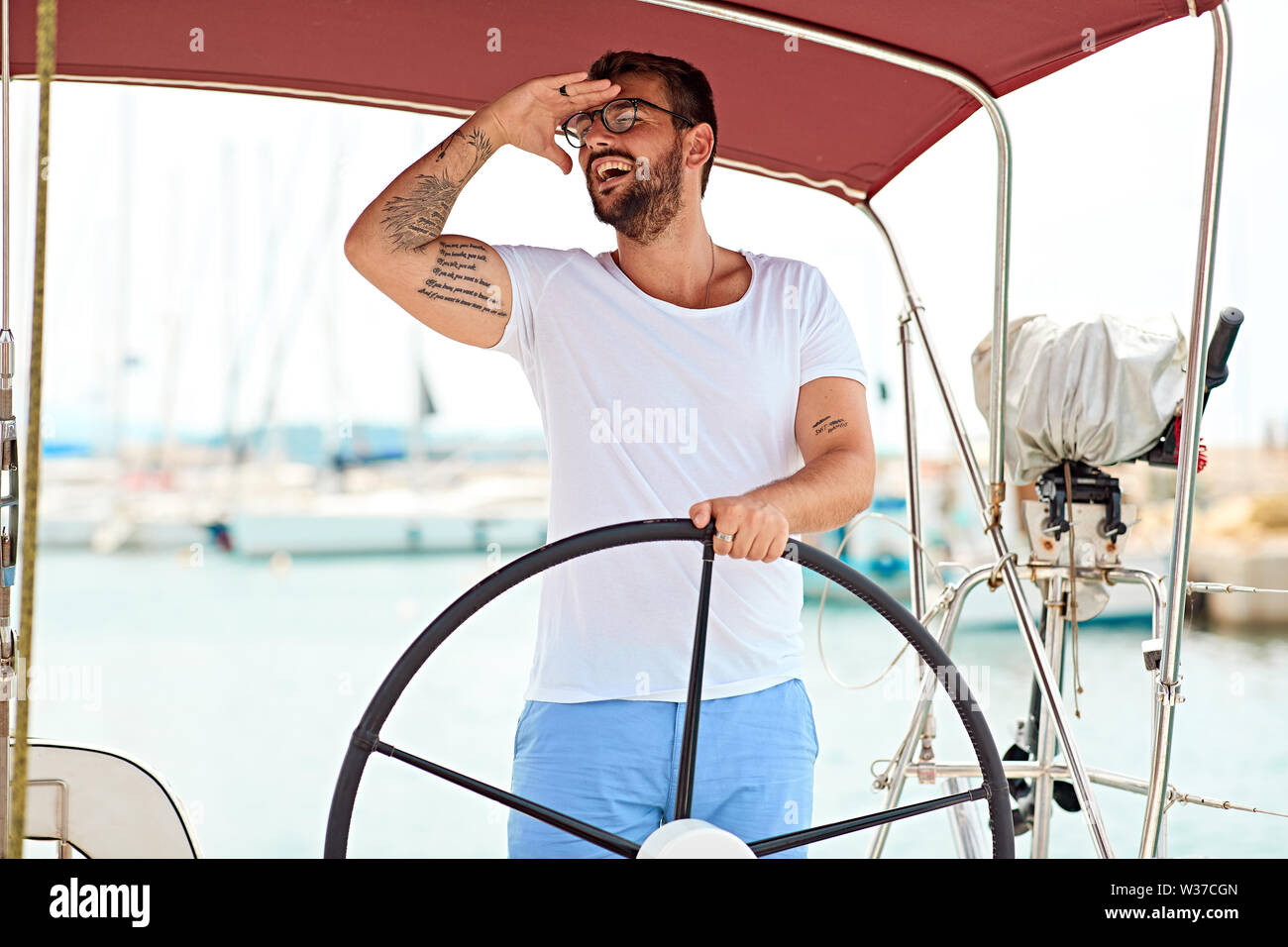 Smiling man sailing on yacht at summer vacation Stock Photo - Alamy