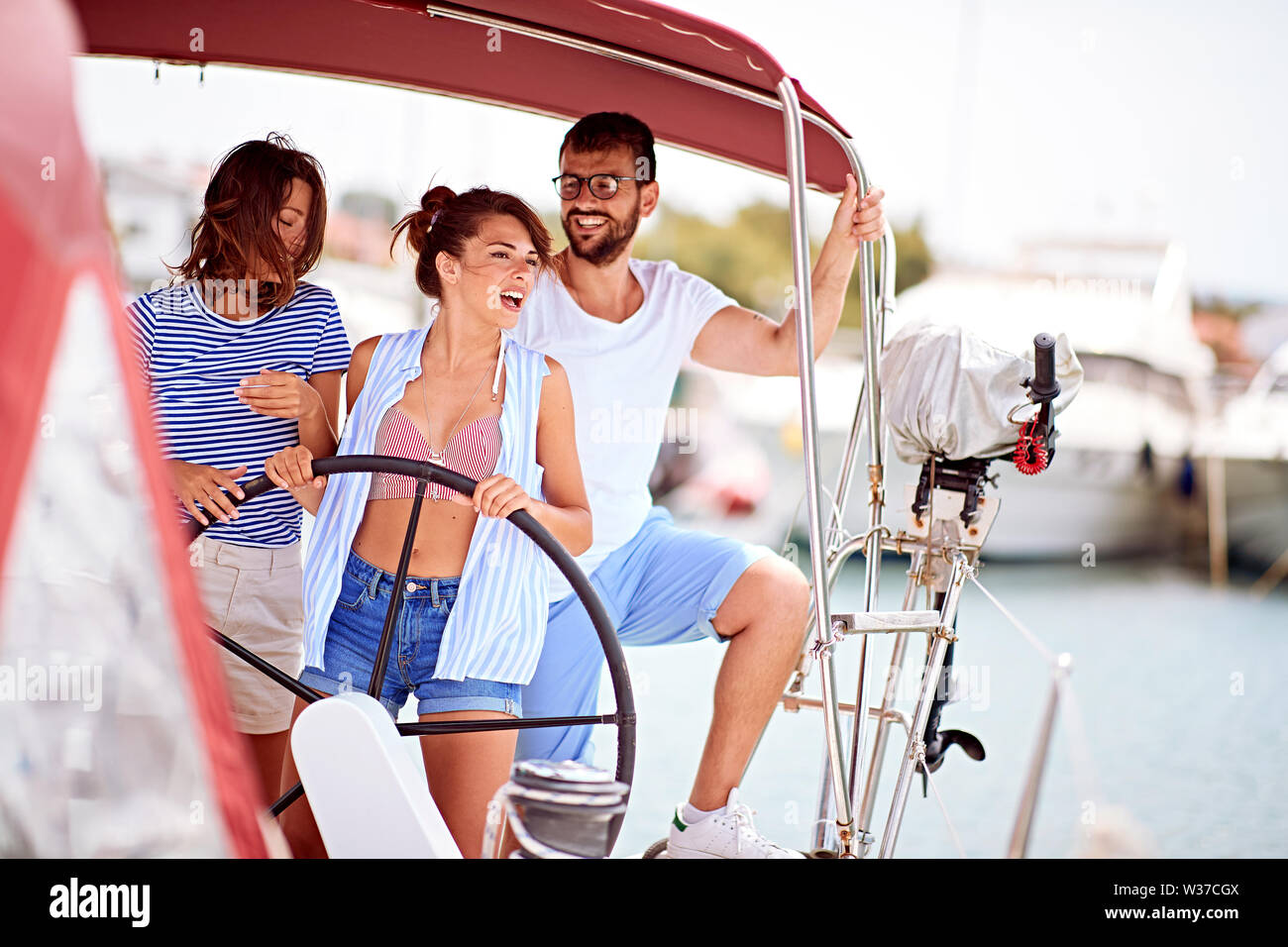Happy girl with friends enjoying a summer day on a boat Stock Photo - Alamy