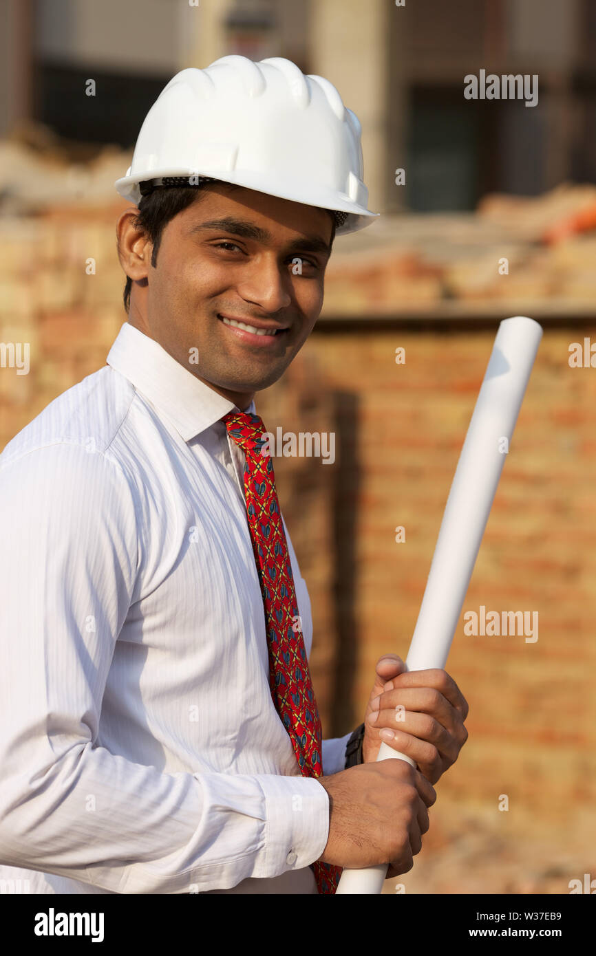 Architect holding blueprint at construction site Stock Photo - Alamy