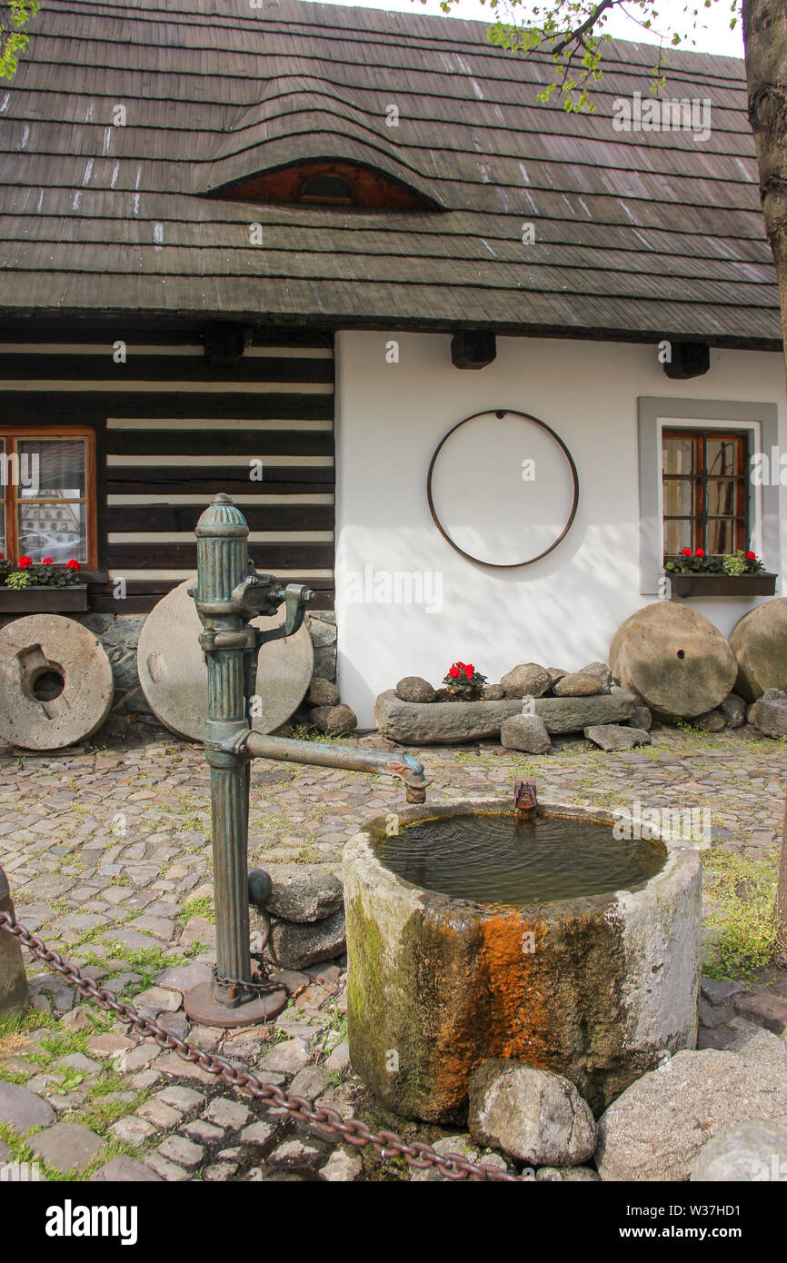 Water column well in cozy old courtyard through rhombus window with ...