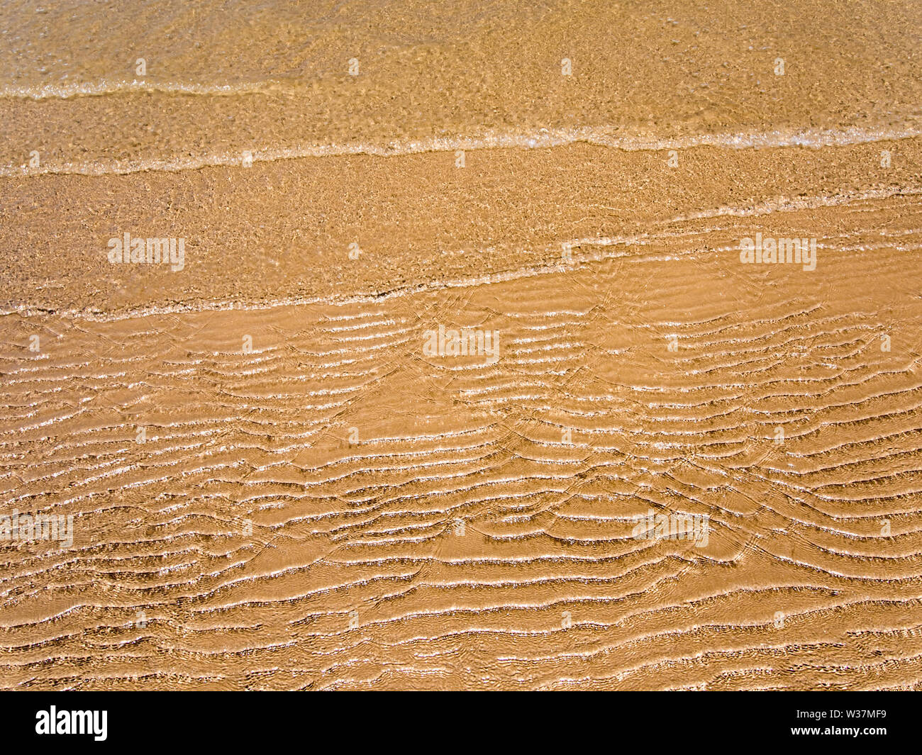 Light reflection on the surface of movement sea on sand beach Stock ...