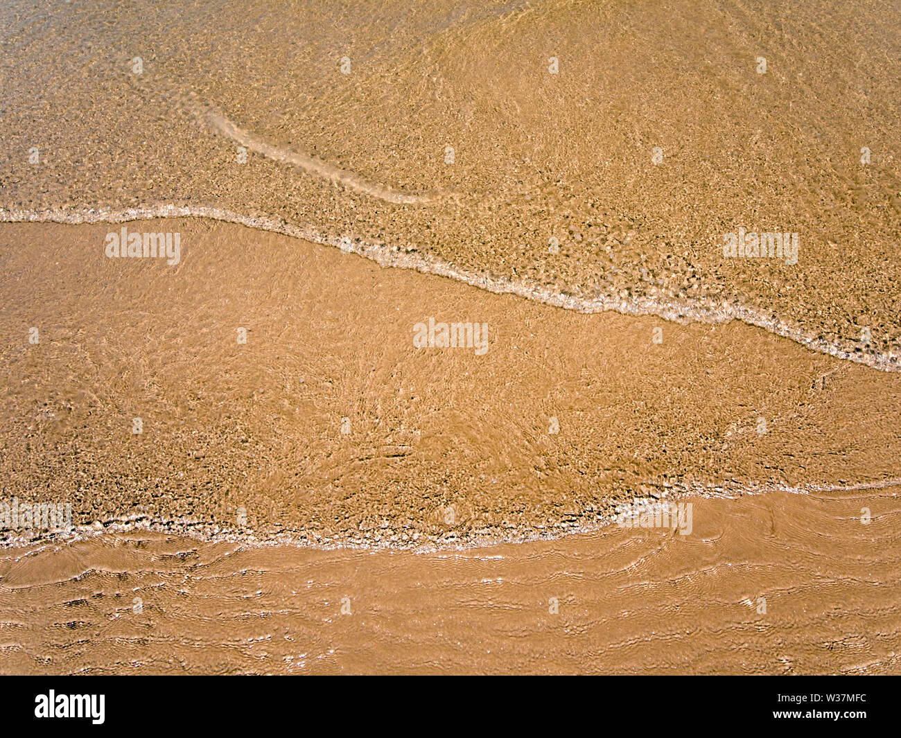 Light reflection on the surface of movement sea on sand beach Stock ...