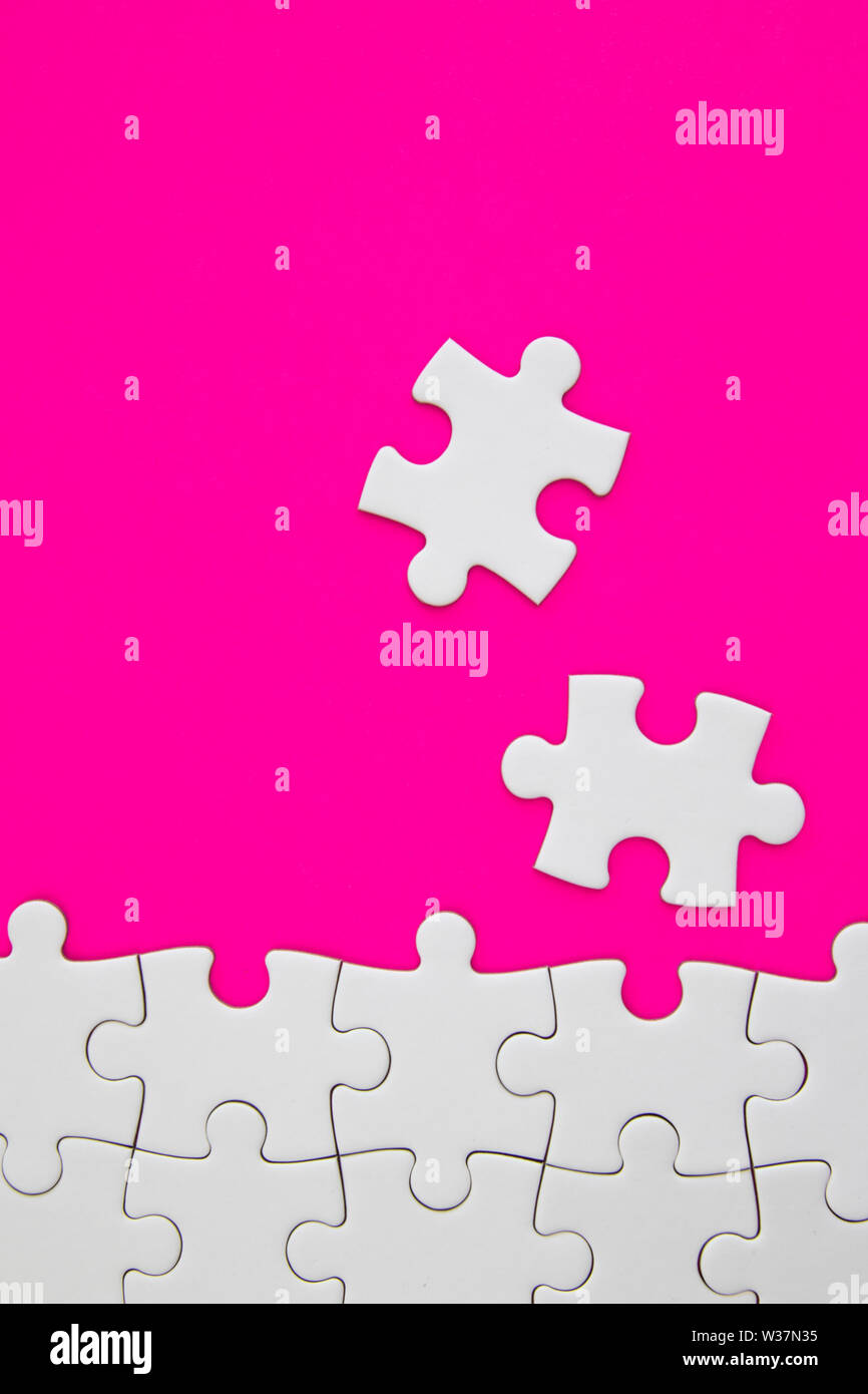 White jigsaw puzzle pieces on pink background with negative space Stock ...