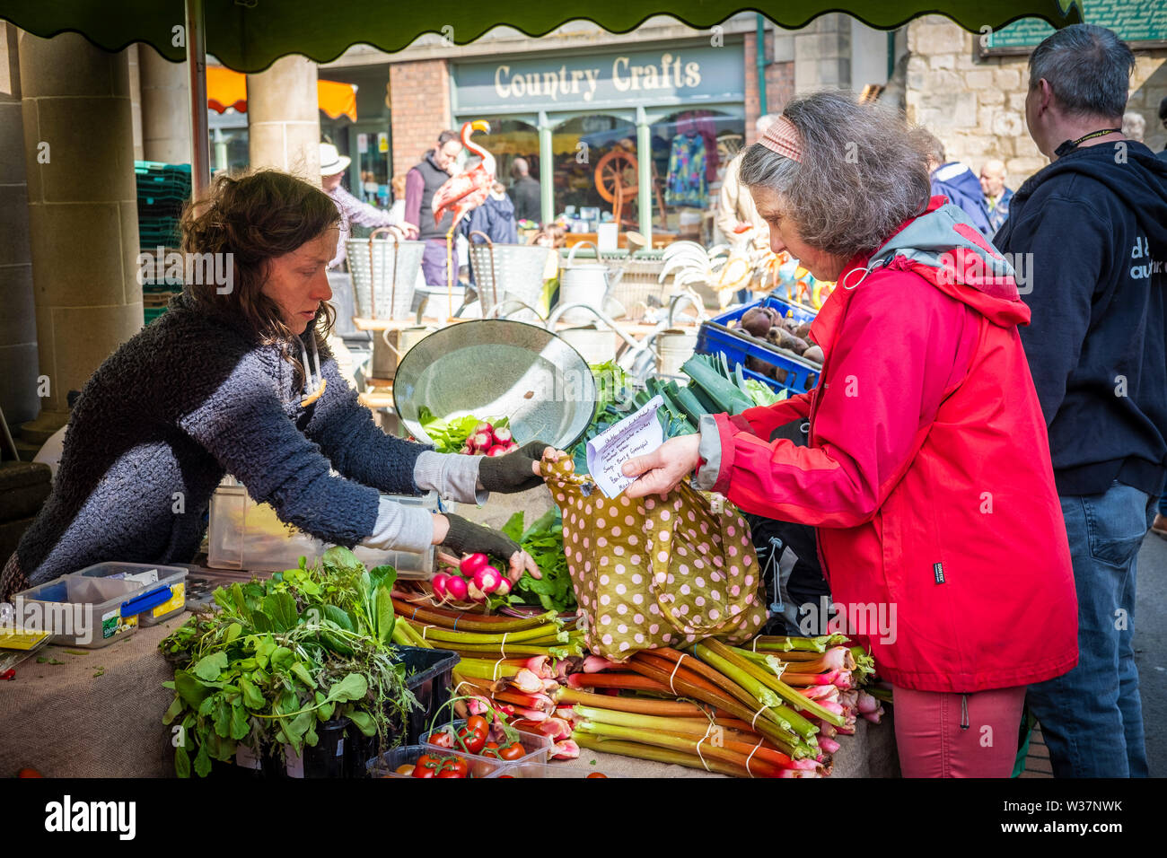 A stall holder selling vegetables to a customer at Stroud Farmers ...