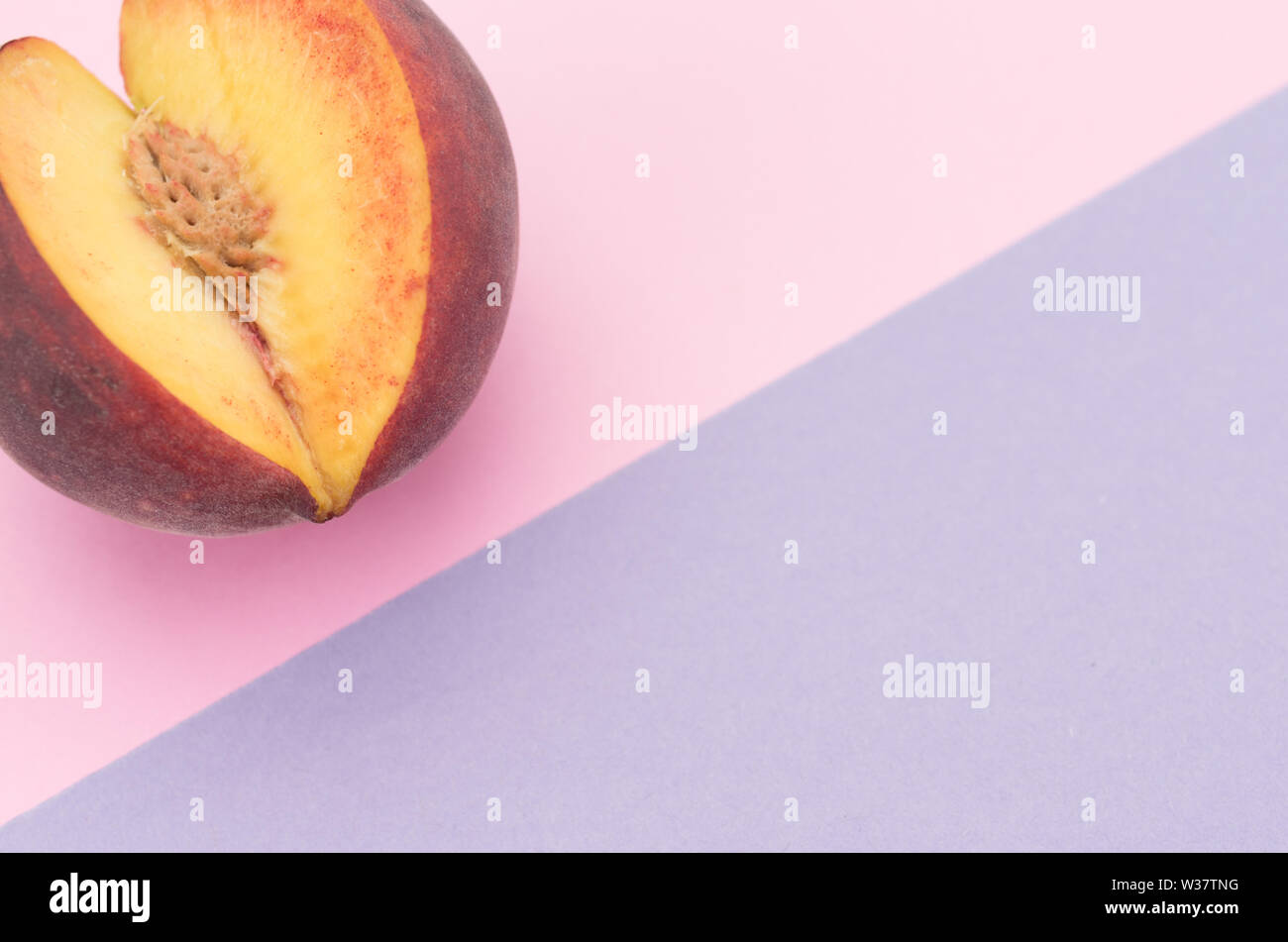 peach on a pink surface still life backdrop Stock Photo - Alamy