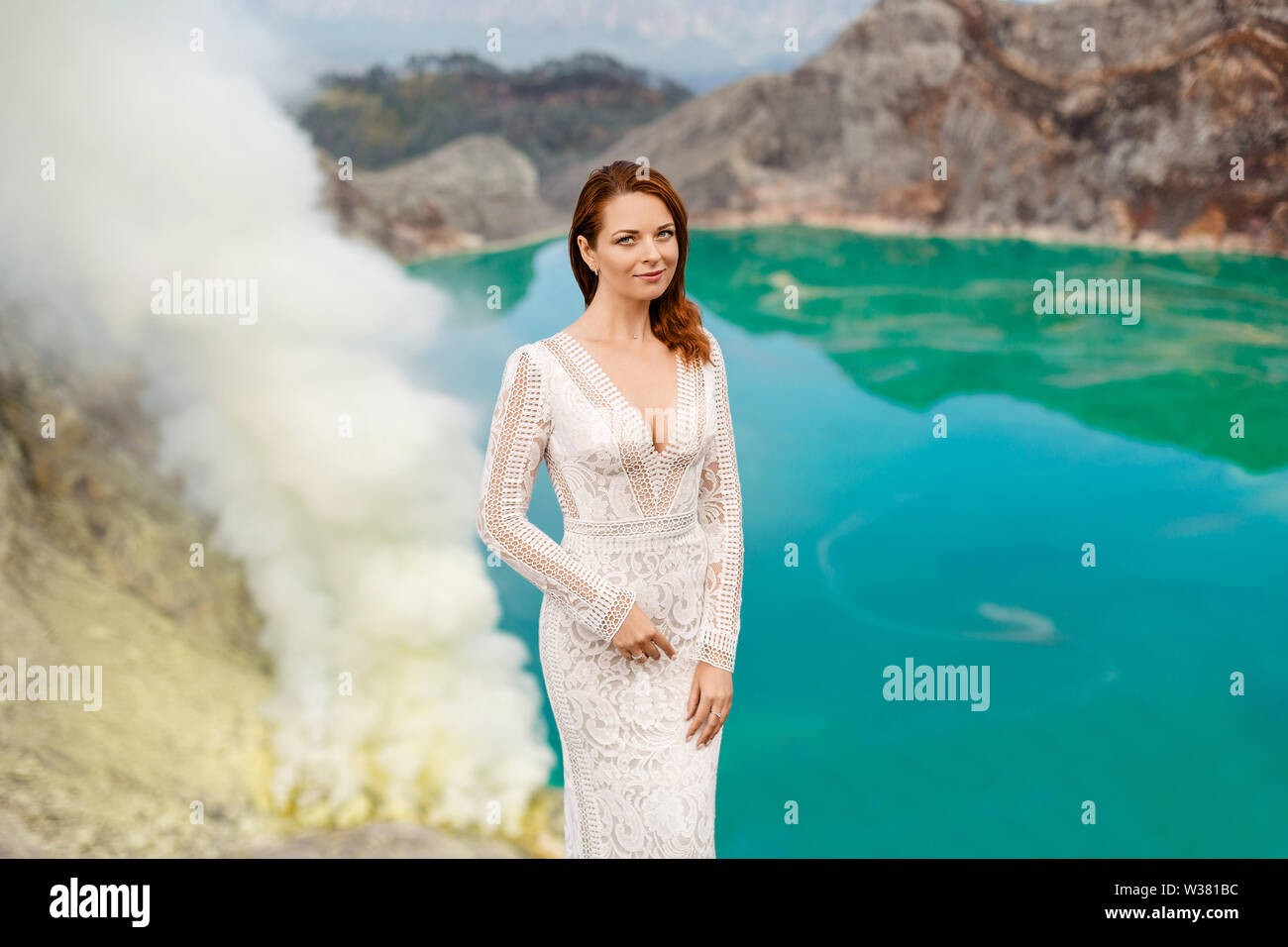 The bride in a white wedding dress against the backdrop of a green ...