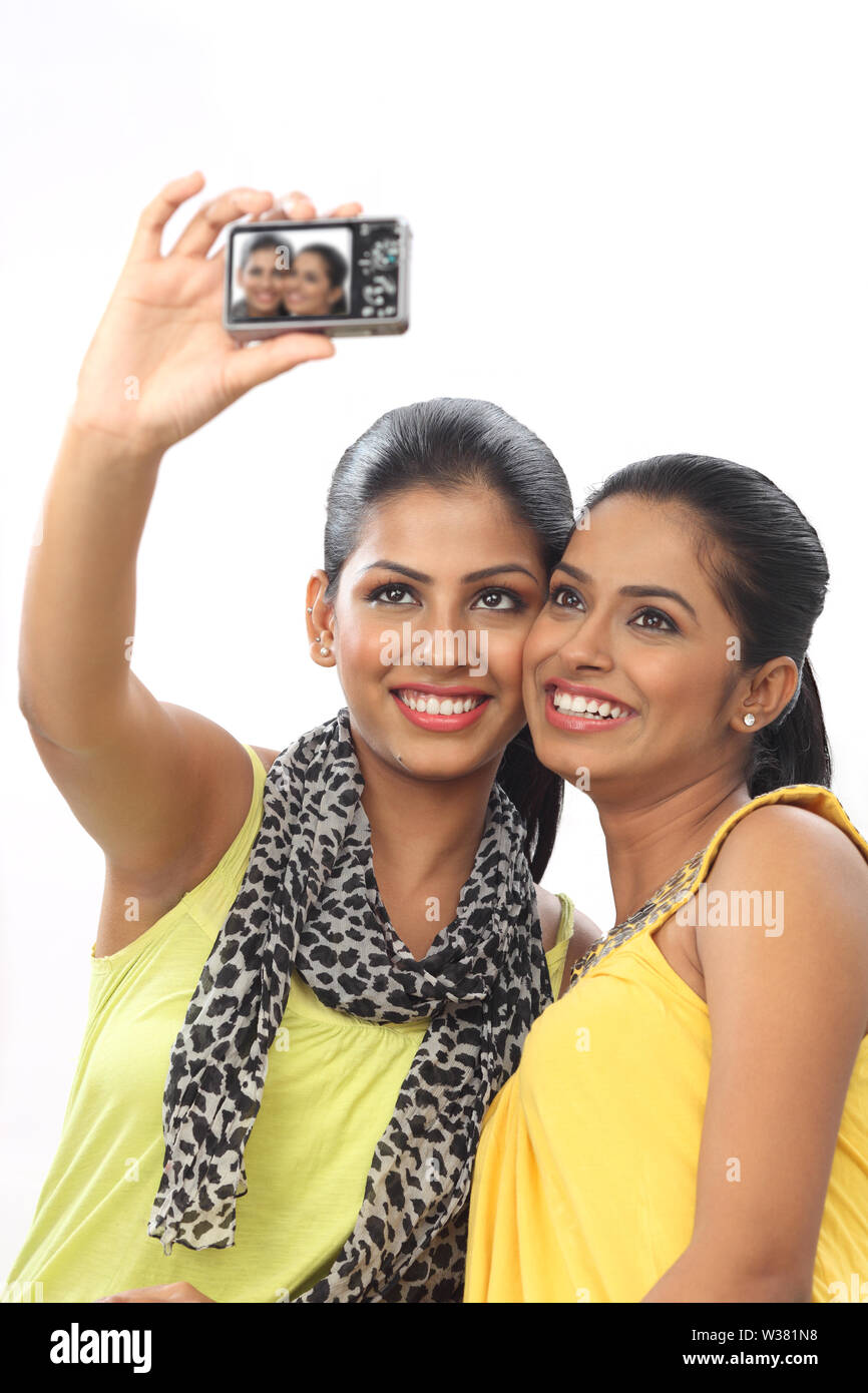 Two friends taking picture of themselves with a digital camera Stock ...