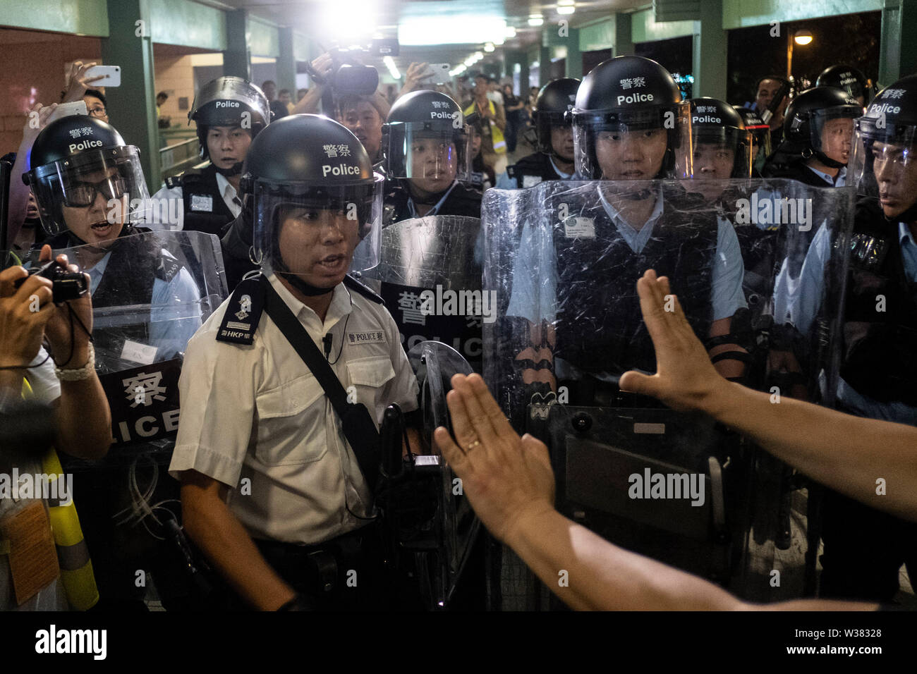 Riot police stand on guard on the road after clashed with protesters ...