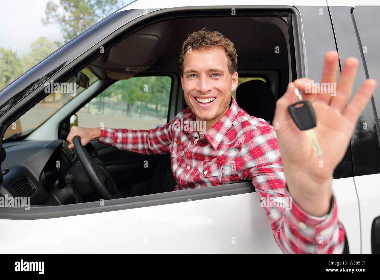 New cars concept - man driving car showing car keys happy looking at ...