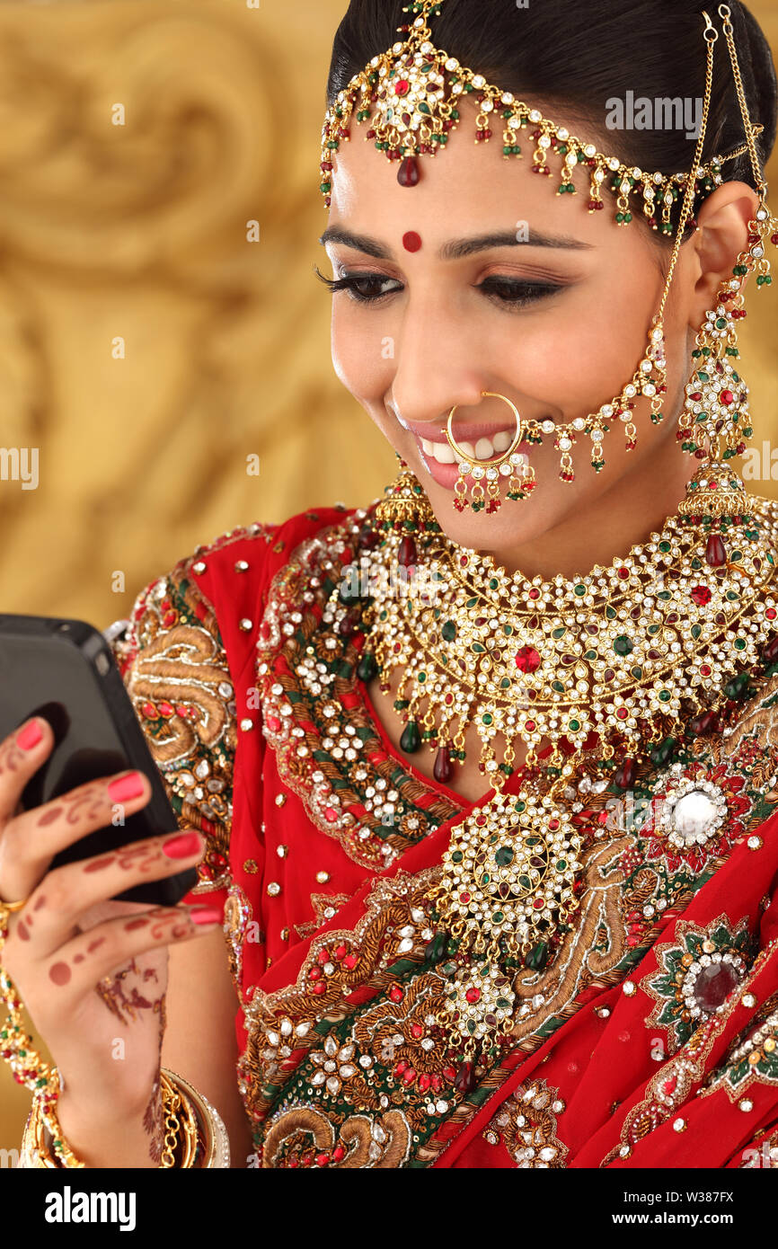 Indian bride text messaging and smiling Stock Photo - Alamy