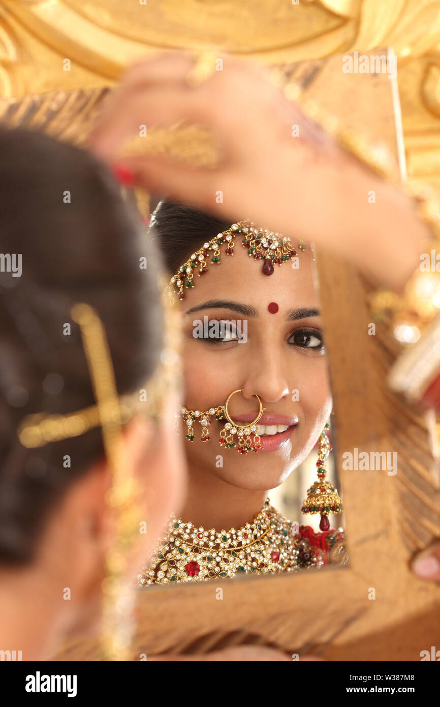 Indian bride admiring herself in mirror Stock Photo - Alamy