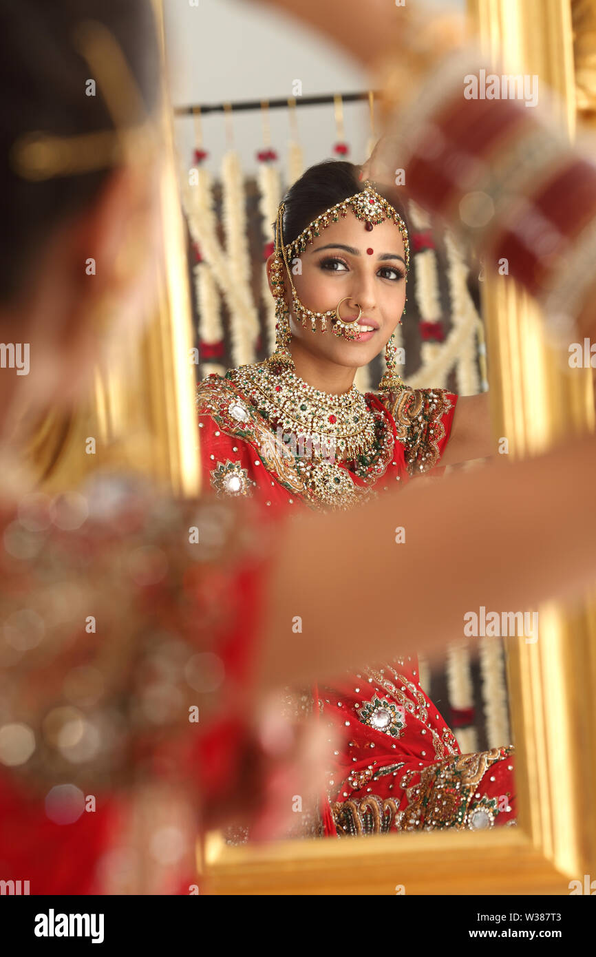 Indian bride adjusting her mang tika looking into mirror Stock Photo ...