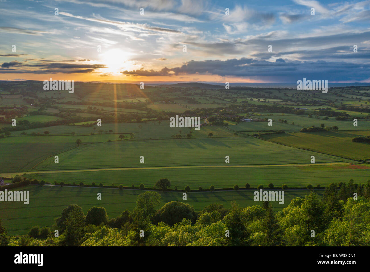 Dramatic sunset over scenic farming fields. Drone shoot over trees in ...