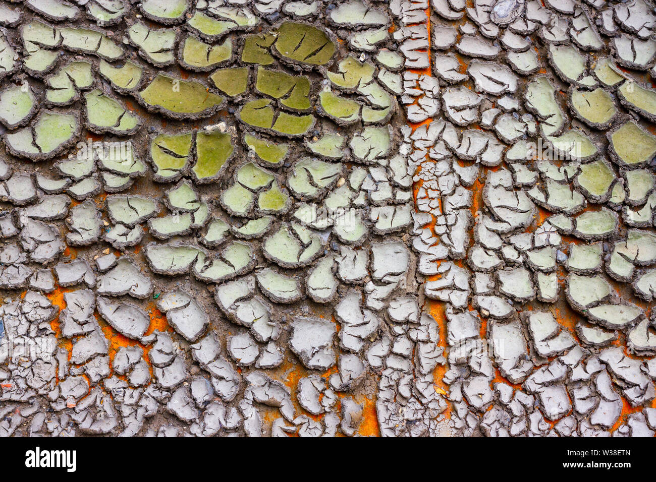 Dried mud on an orange metal background Stock Photo - Alamy