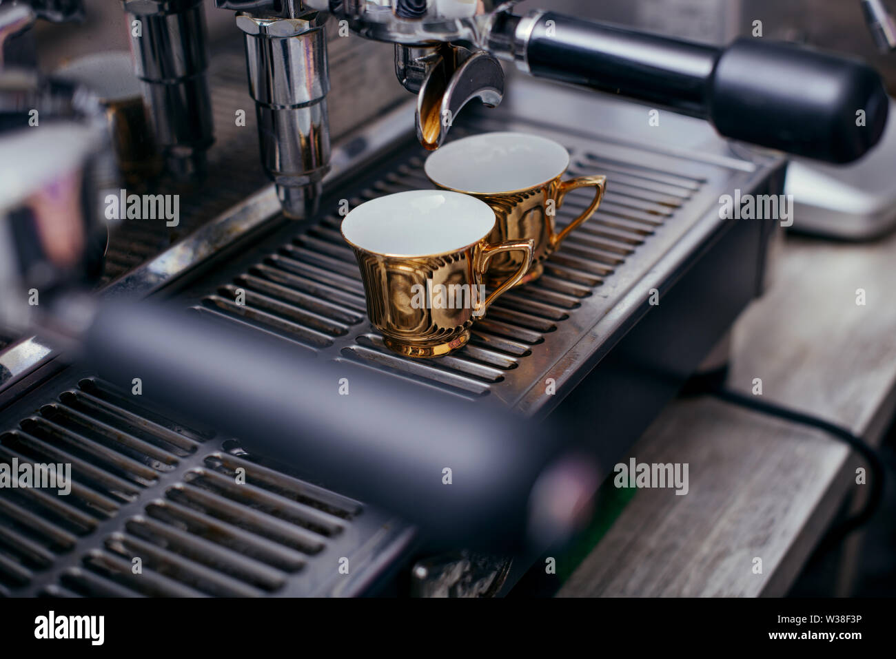 Professional coffee machine with gold cup and pouring drink Stock Photo ...