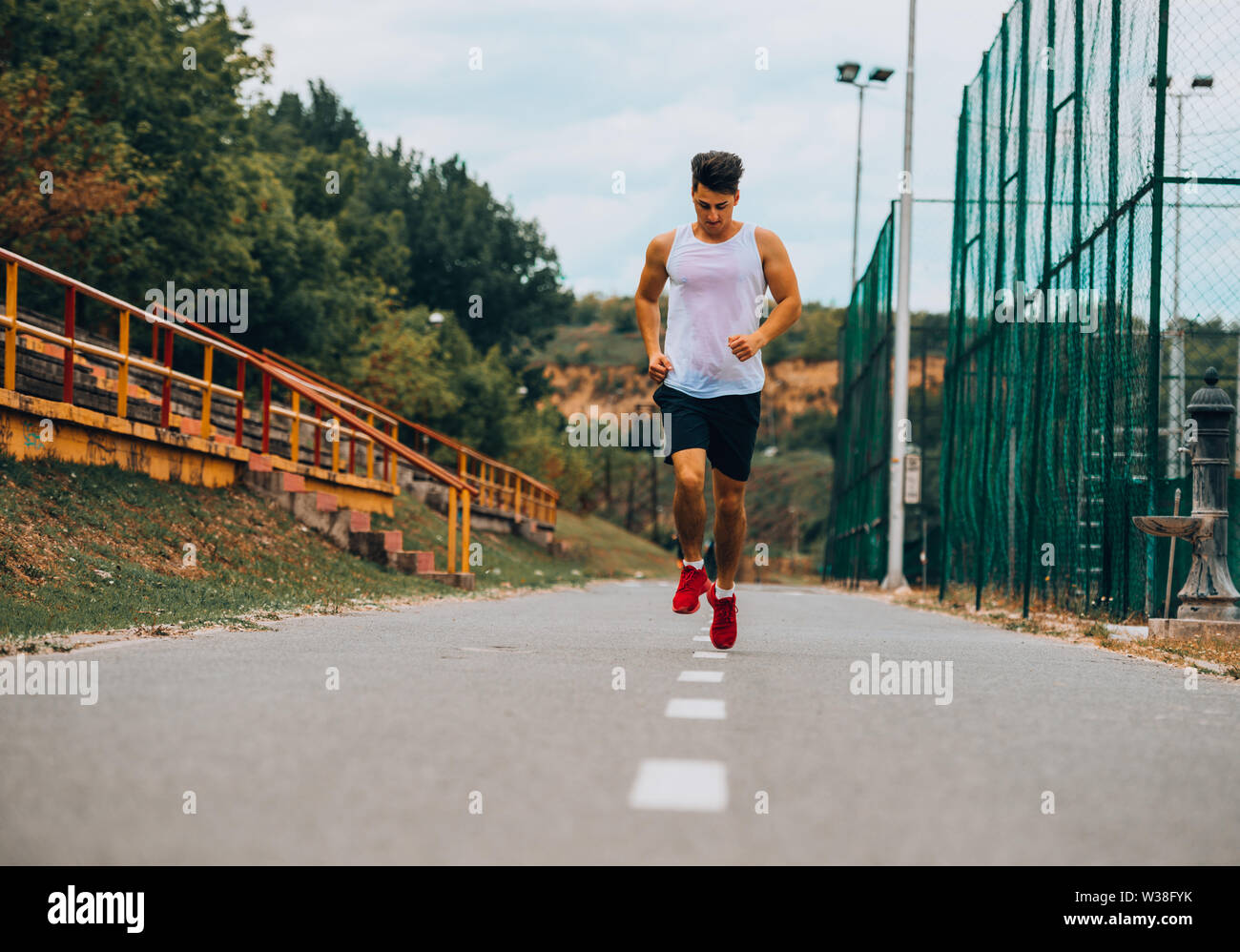 Attractive man male athlete running training exercising on track Stock ...