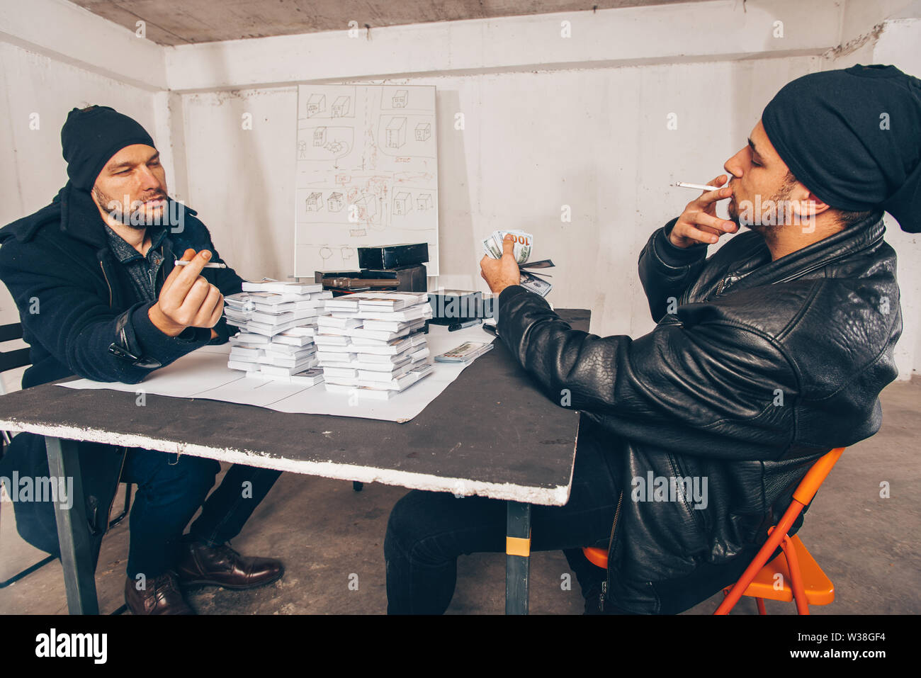 Dangerous burglars counting stolen cash from robbery Stock Photo - Alamy