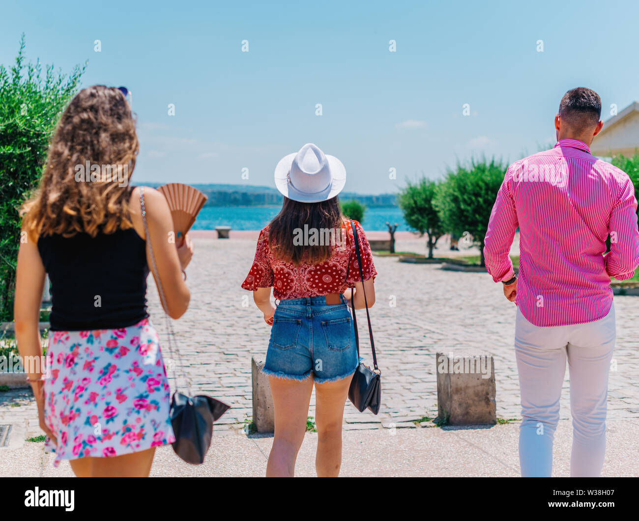Tourists sightseeing and walking at a modern city boardwalk on a ...