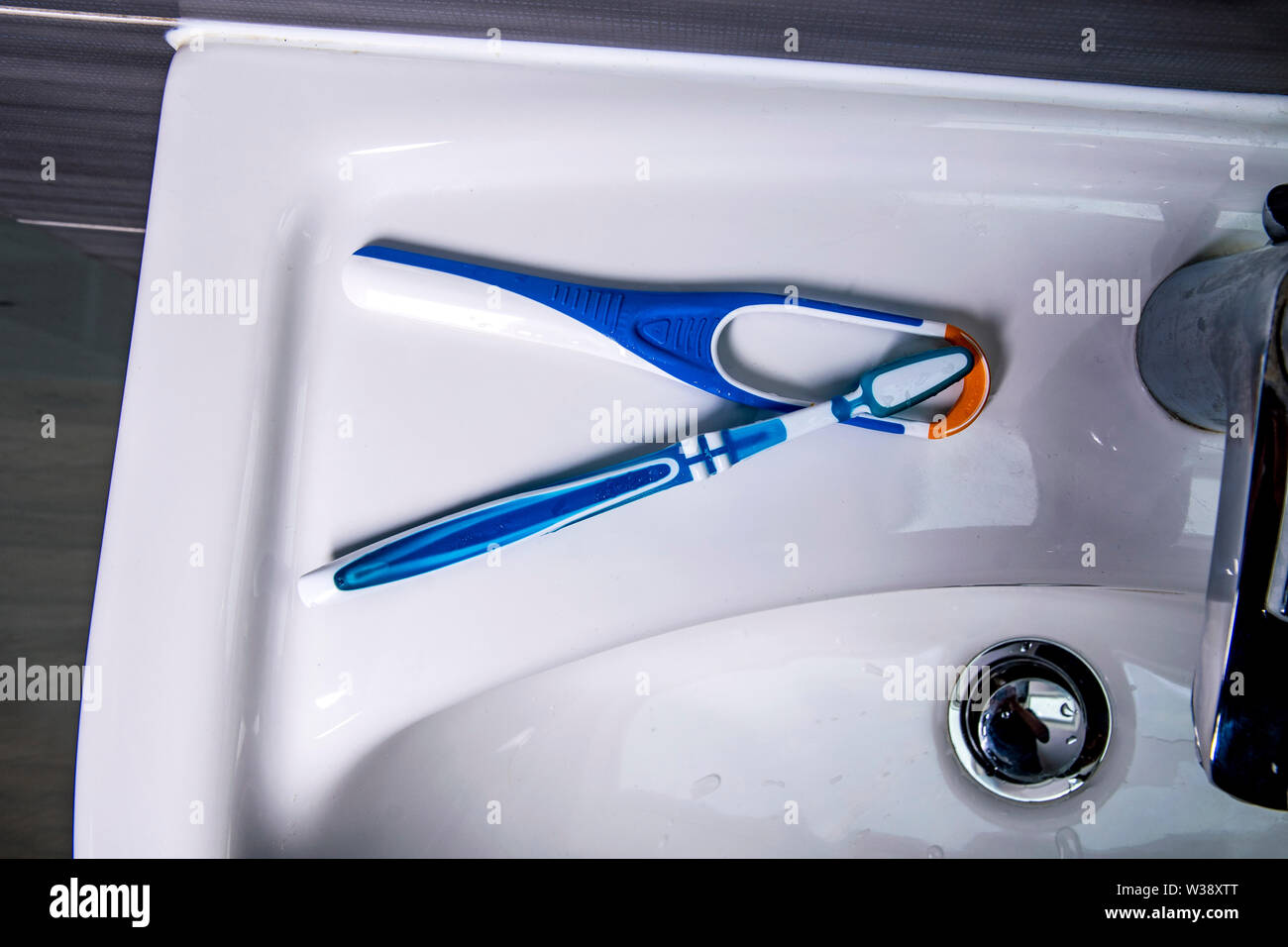 Tongue cleaner with toothbrush on the wash basin in the bathroom Stock ...