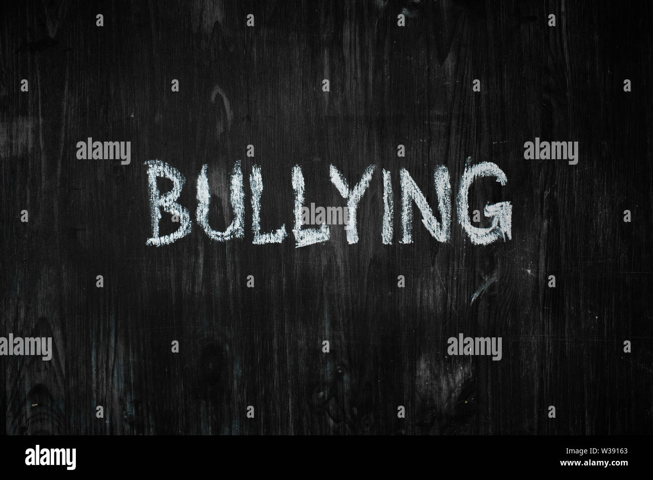 Bullying word handwritten on black wood background. Sign, concept of ...