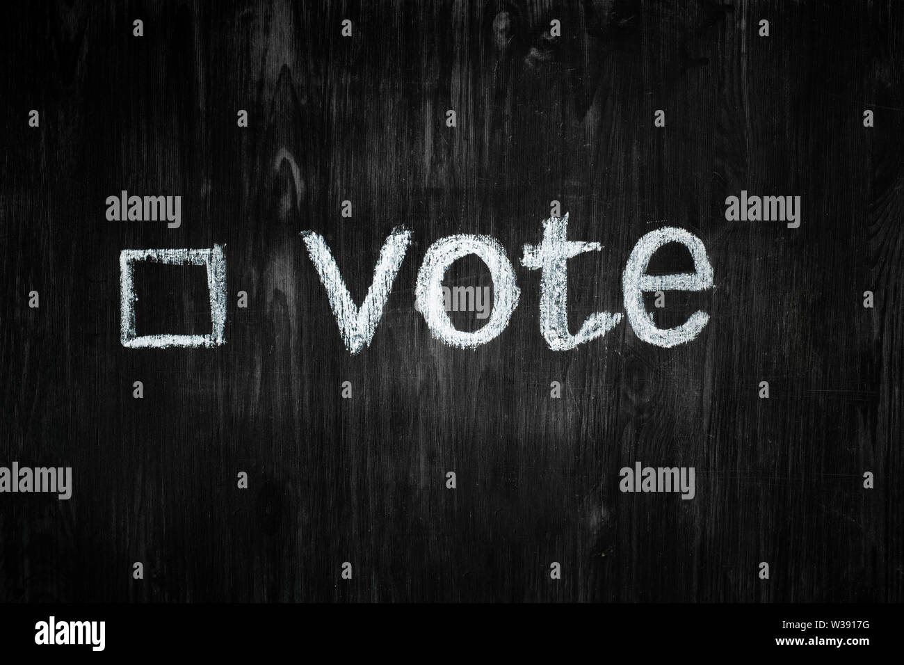 Political activism sign: handwritten word "vote" in black background ...