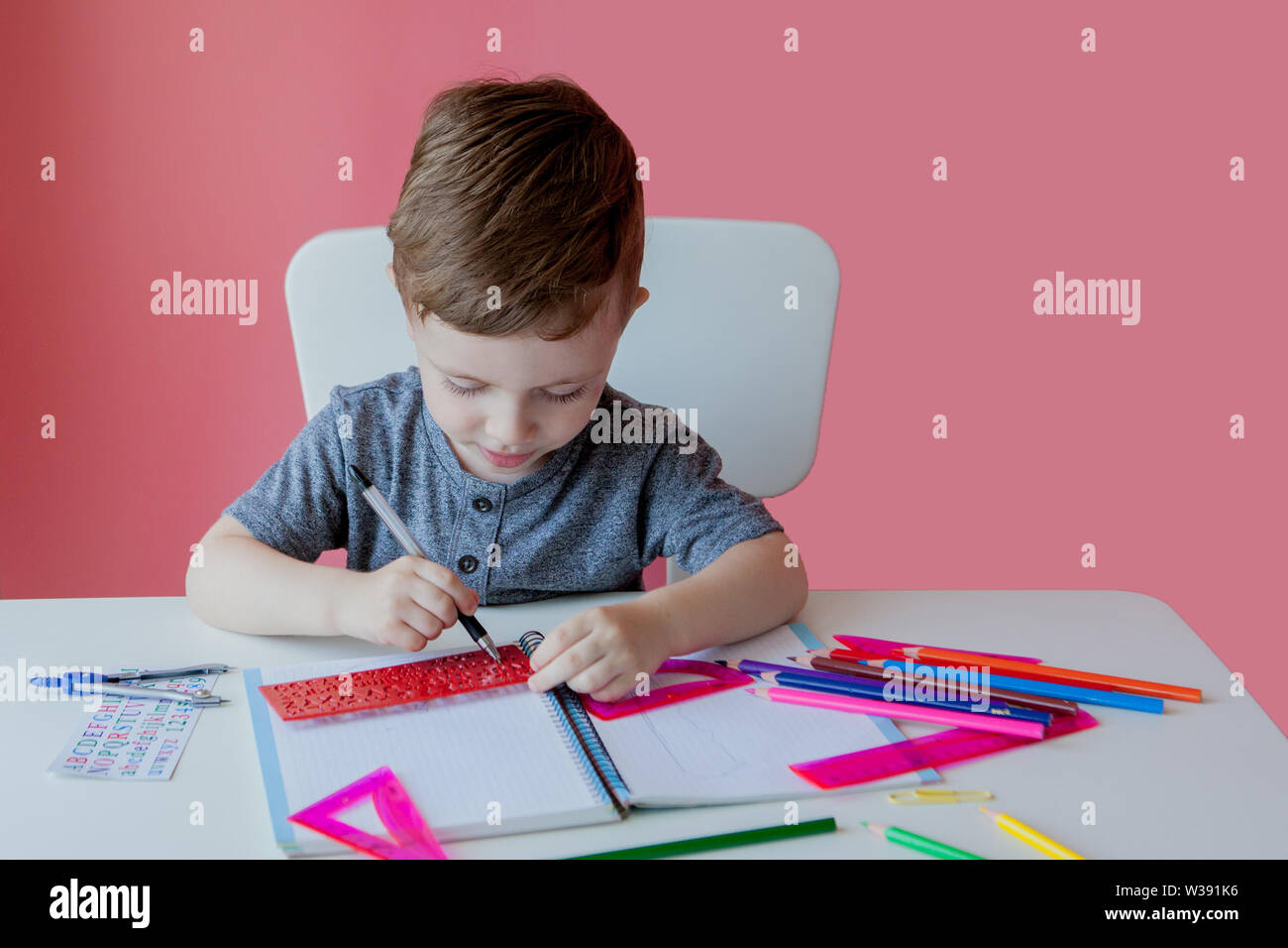 Portrait of cute kid boy at home making homework. Little concentrated ...