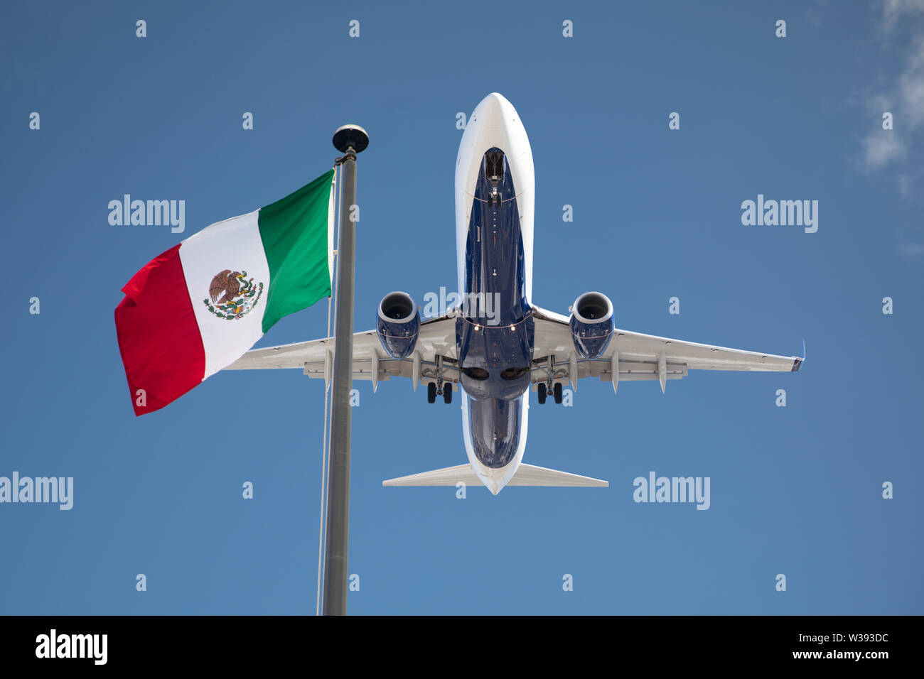 Bottom View of Passenger Airplane Flying Over Waving Mexico Flag On ...