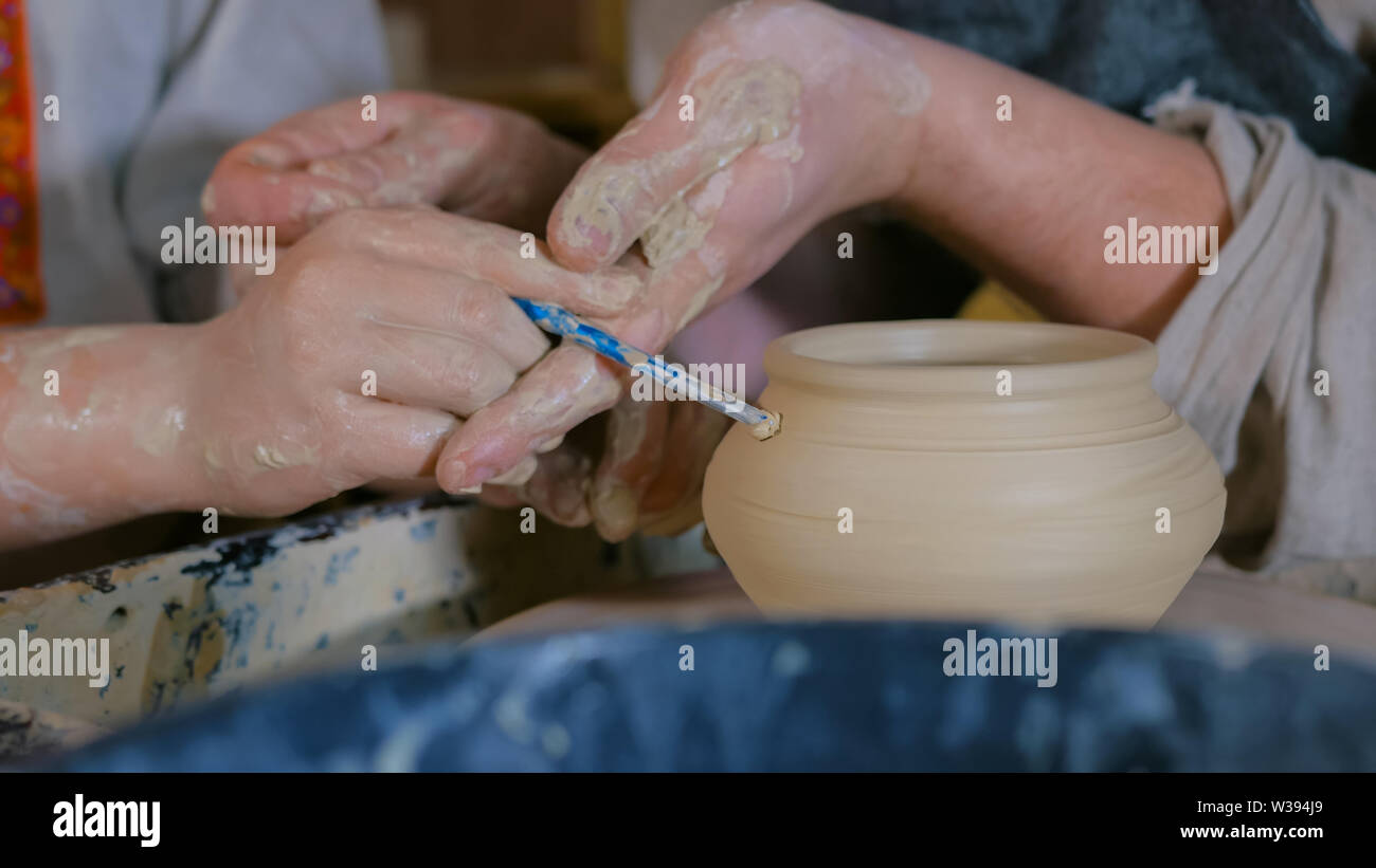 Potter showing how to work with ceramic in pottery studio Stock Photo ...