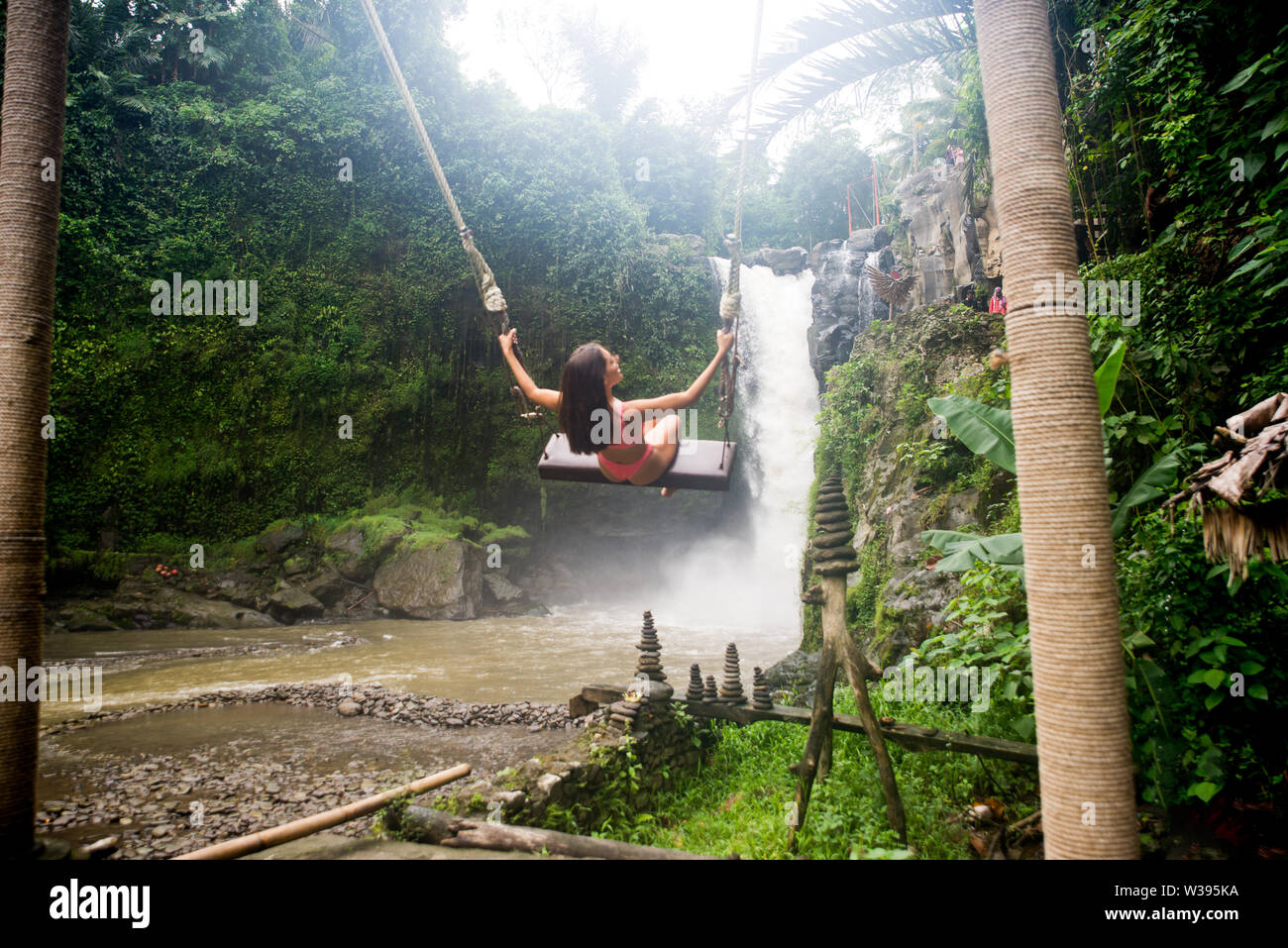 Beautiful young woman posing at the great Tegenungan waterfall in the ...