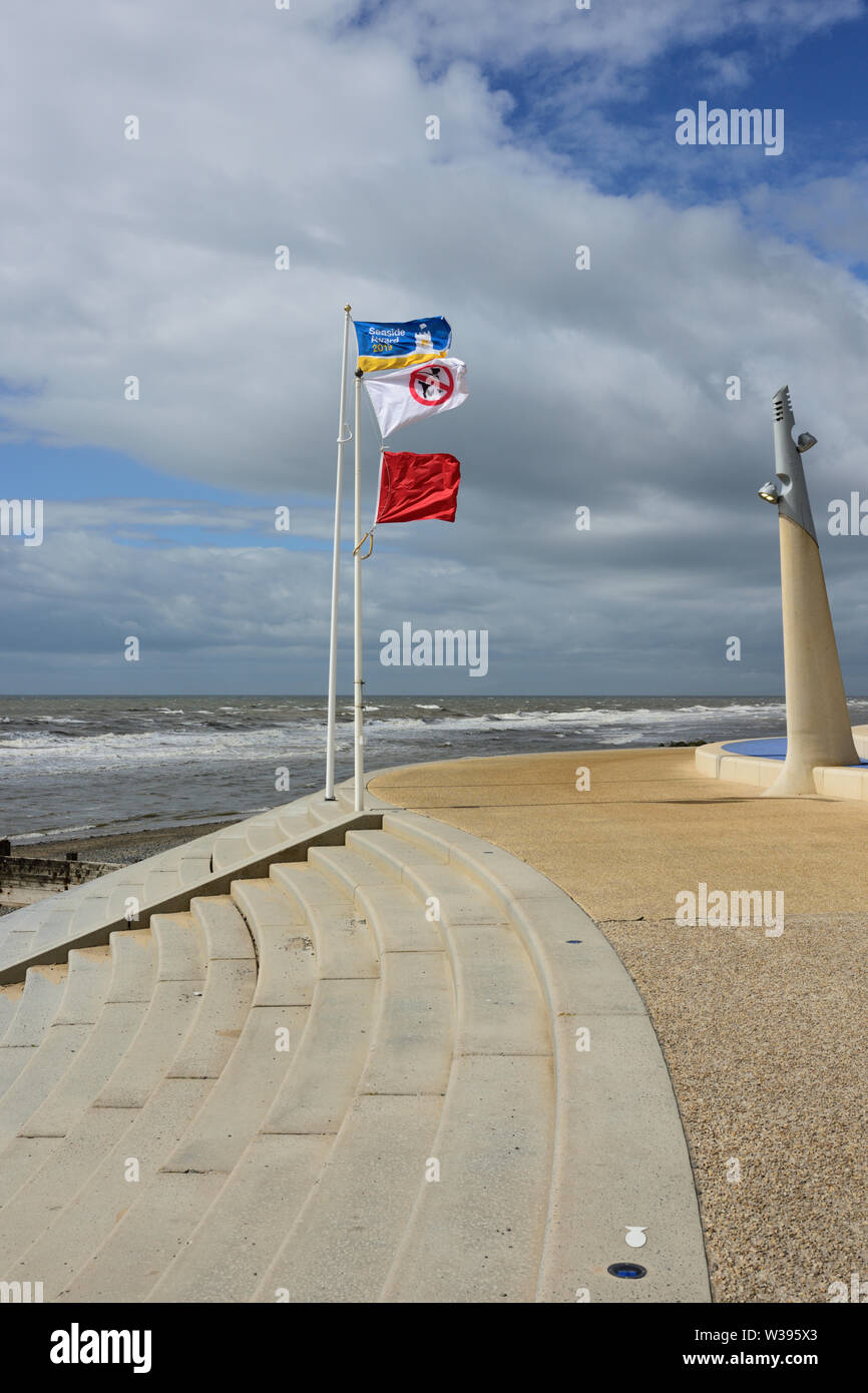 Concrete stepped revetment and promenade with three warning flags on ...